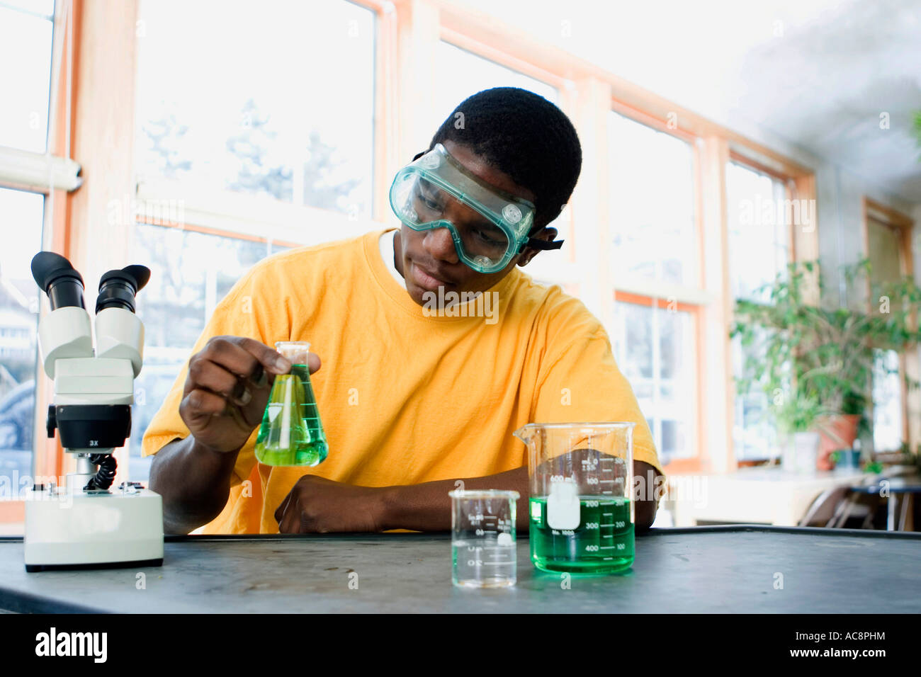Student holding a beaker in a science lab Stock Photo - Alamy
