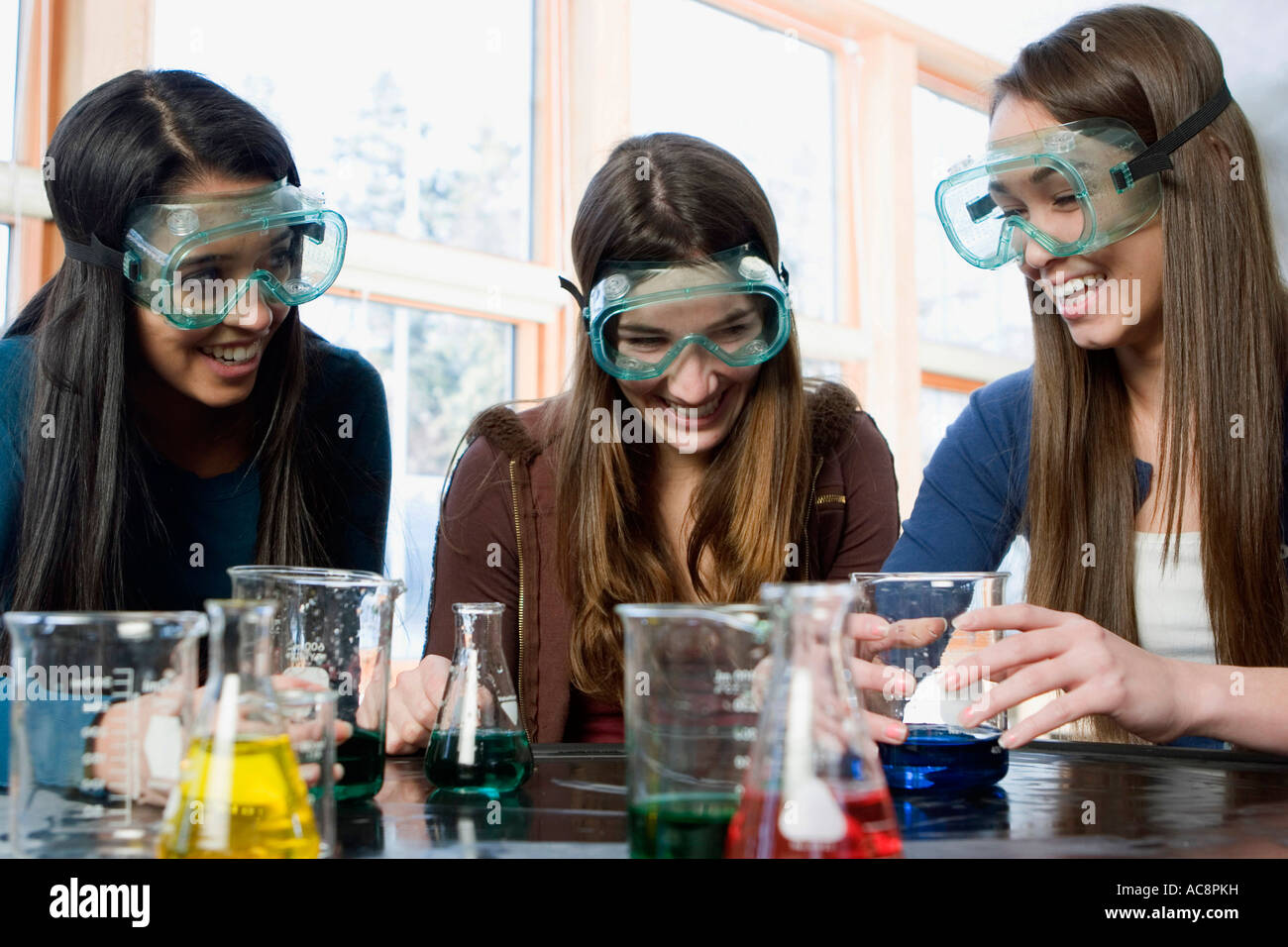 Three students with beakers laughing in a science lab Stock Photo - Alamy