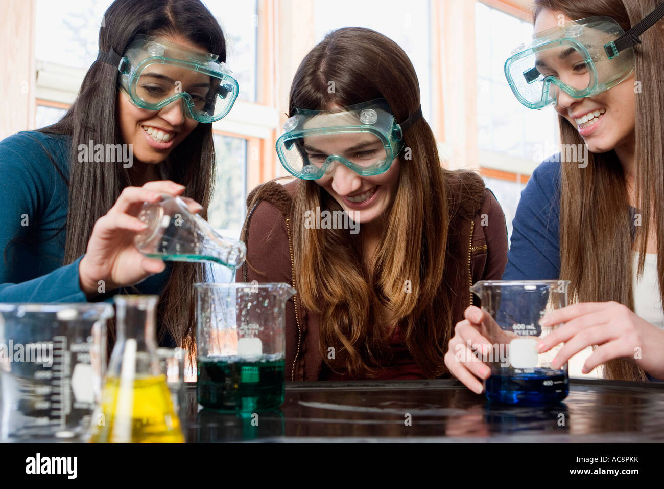 Three students performing an experiment in a science lab Stock Photo ...