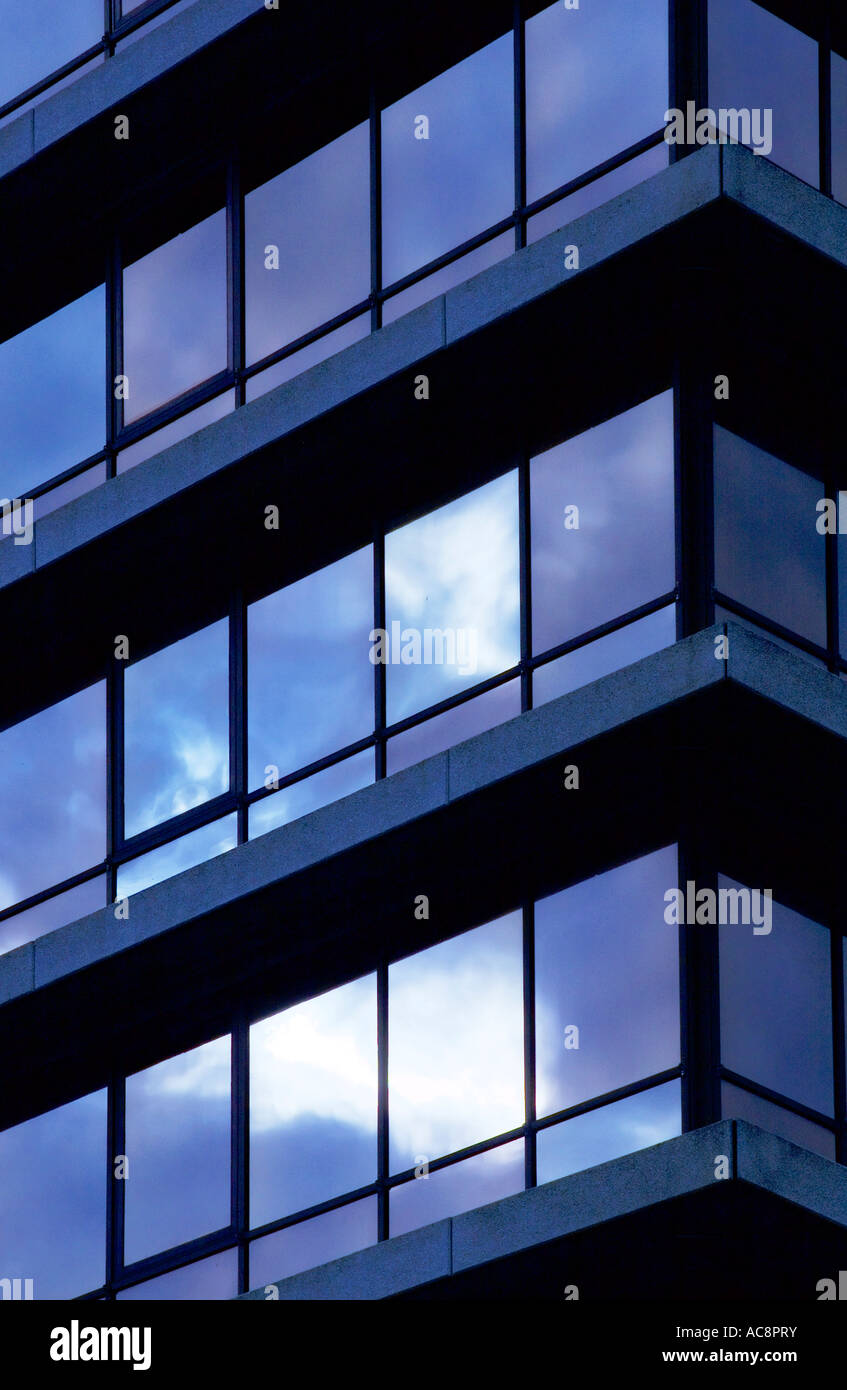 Clouds reflecting in the windows of a tall glass building Stock Photo - Alamy