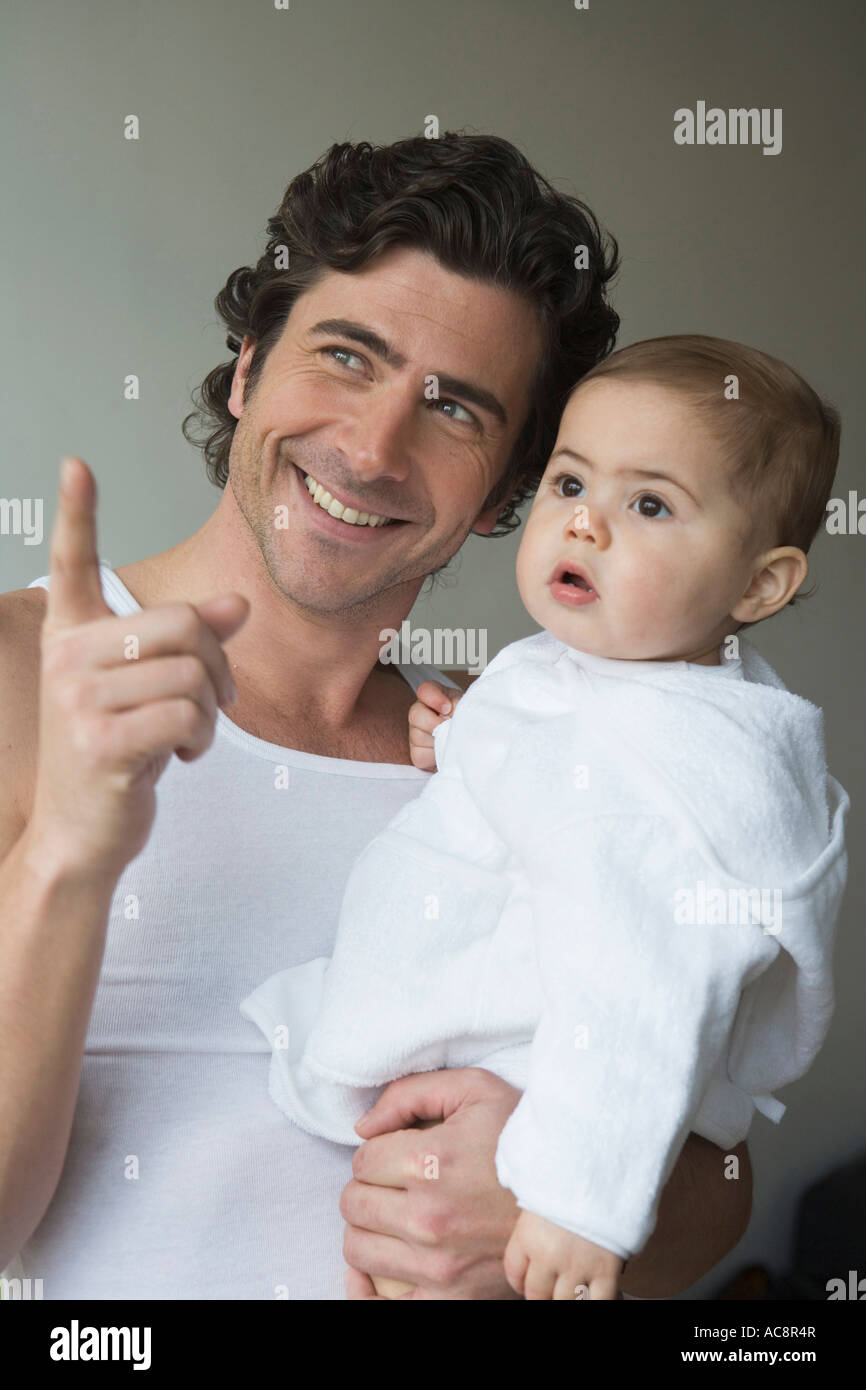 Mid adult man holding his baby and pointing Stock Photo - Alamy