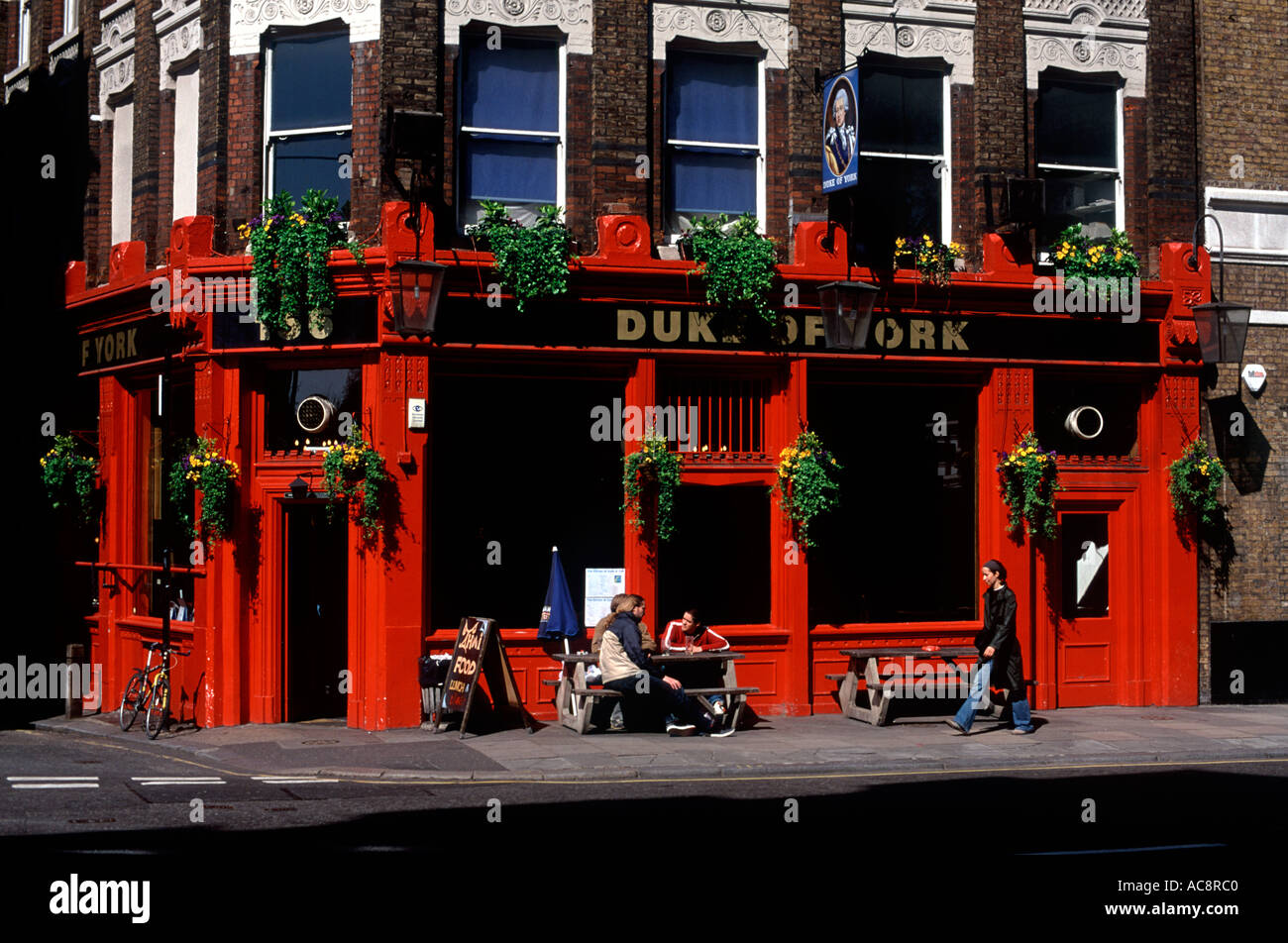 Bright red pub, popular with bicycle couriers, with people enjoying a ...