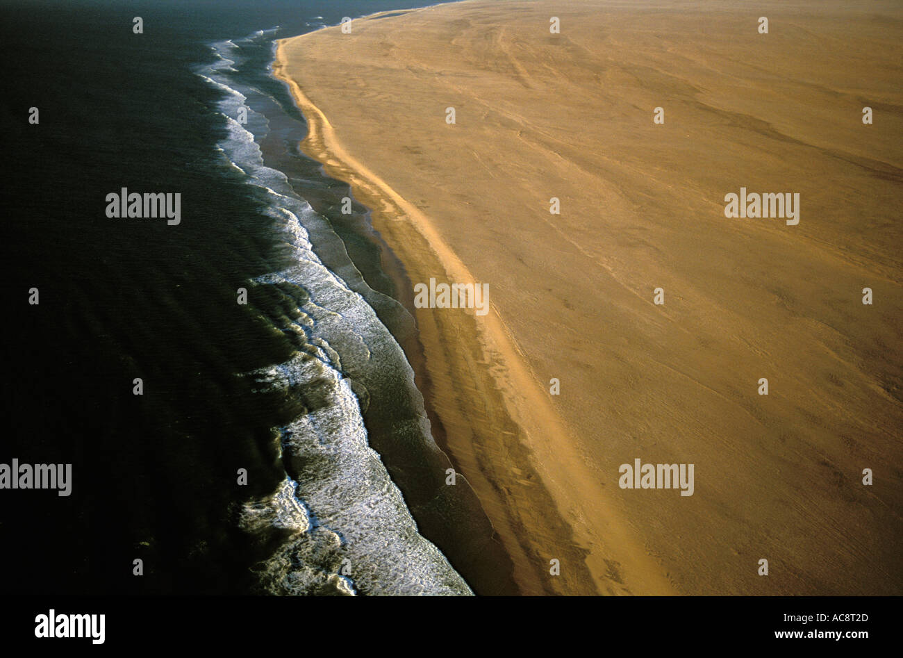 Waves of the Atlantic Ocean meet the sand of Namib Desert Aerial ...