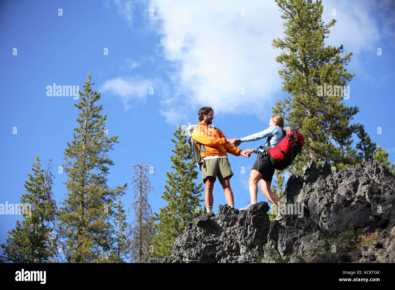 Backpacking couple celebrate at the top of a mountain Stock Photo - Alamy