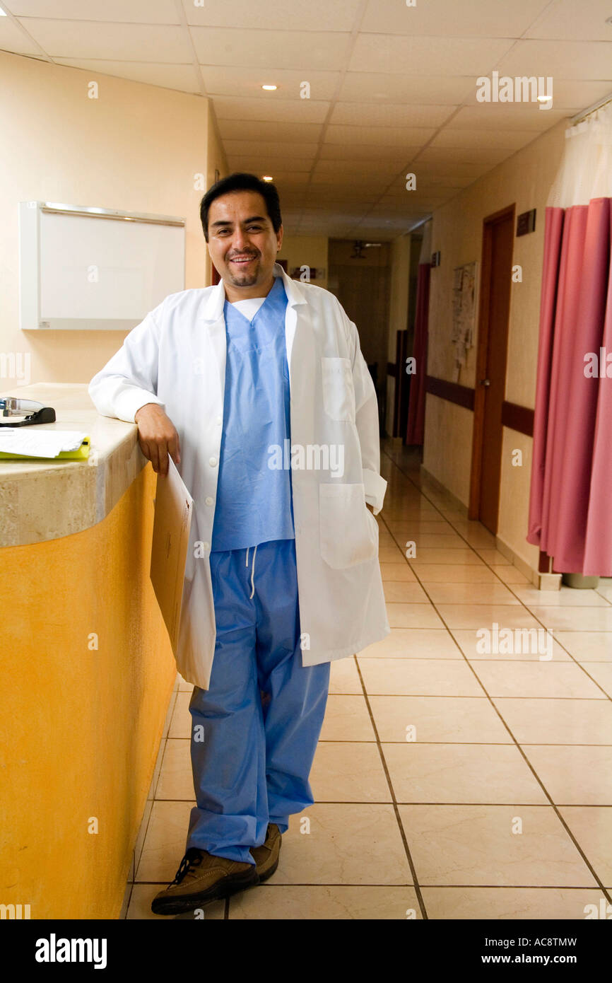 Male doctor standing at a counter and smiling Stock Photo - Alamy