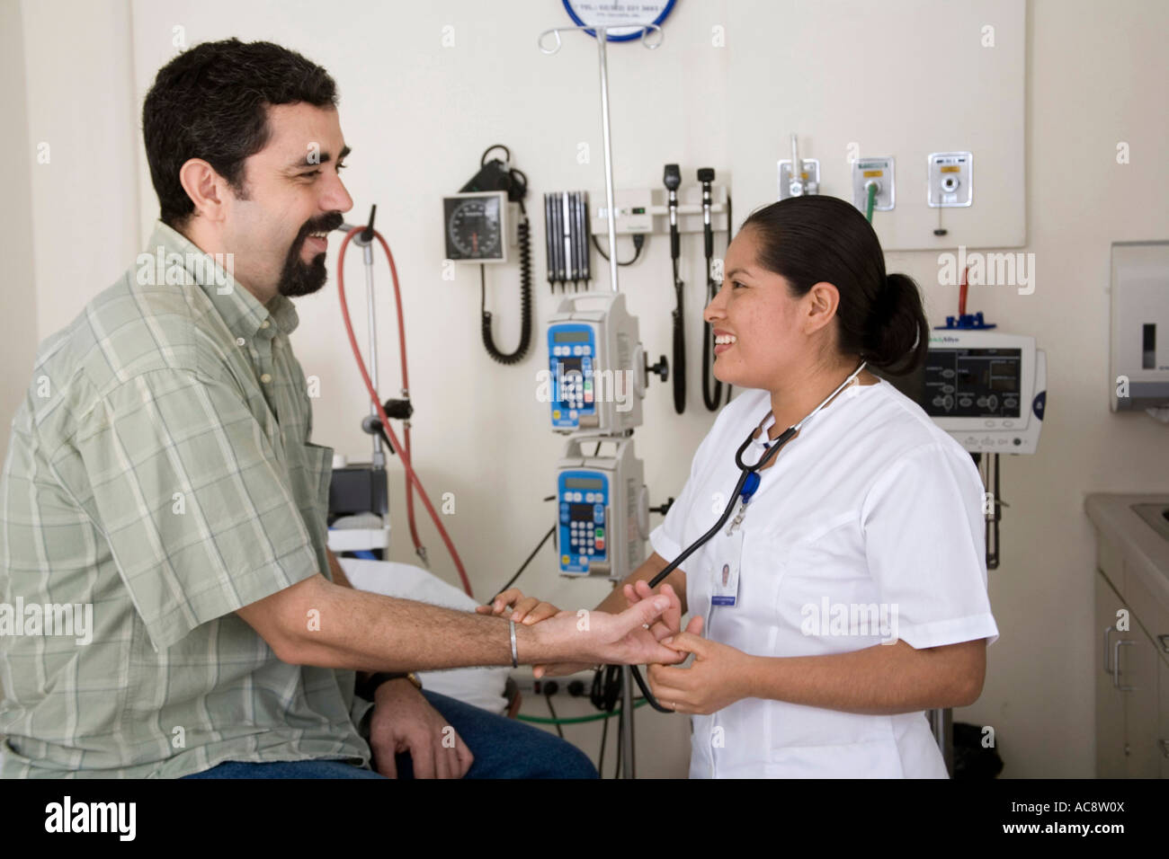 Female nurse checking the pulse of a patient and smiling Stock Photo ...