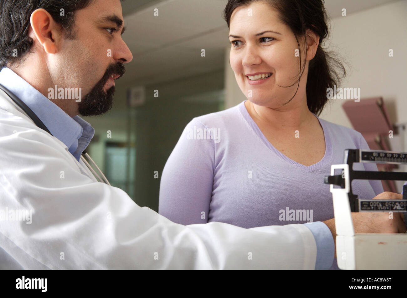 Male doctor measuring the weight of a patient Stock Photo - Alamy