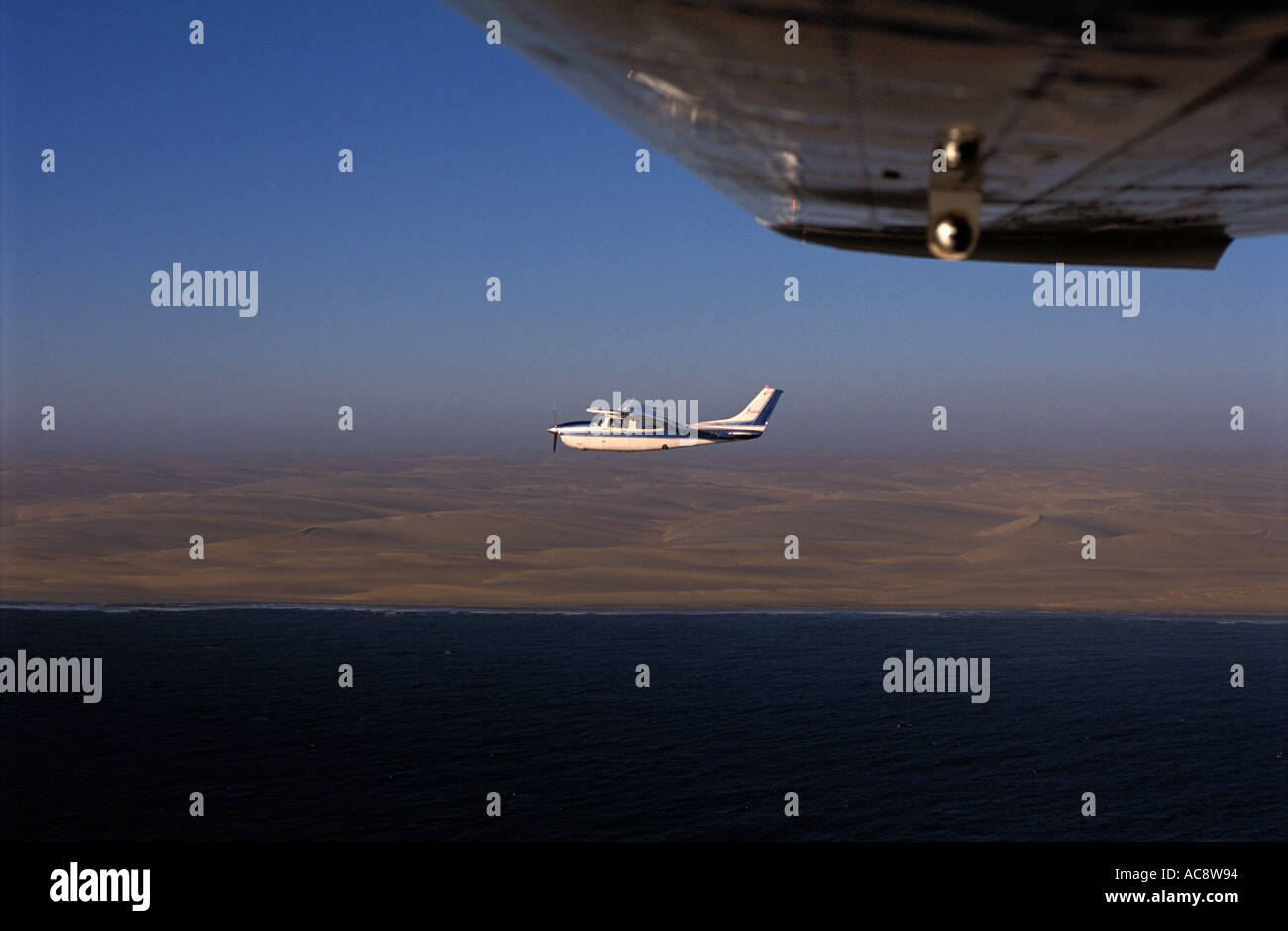 Cessna plane flying above Atlantic coast of the Namib Desert Namibia ...