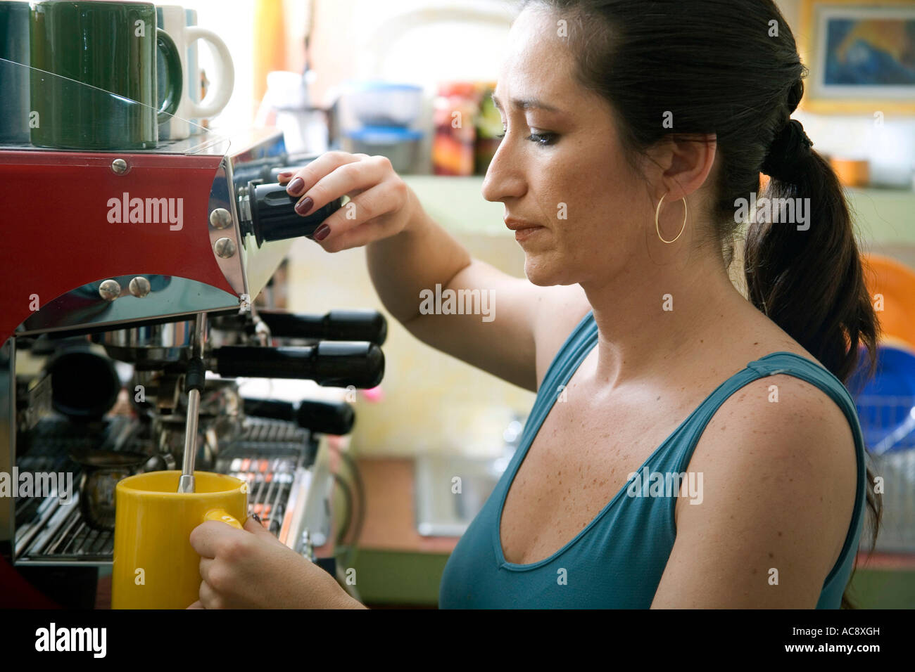 Mid adult woman operating a coffee maker in a cafe Stock Photo - Alamy