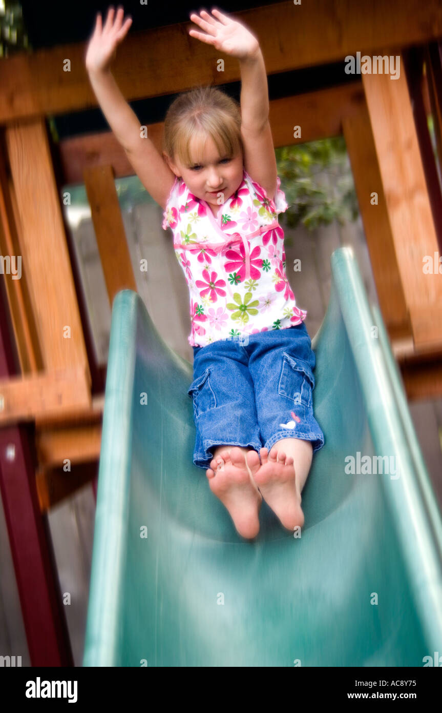 Girl going down slide Stock Photo - Alamy