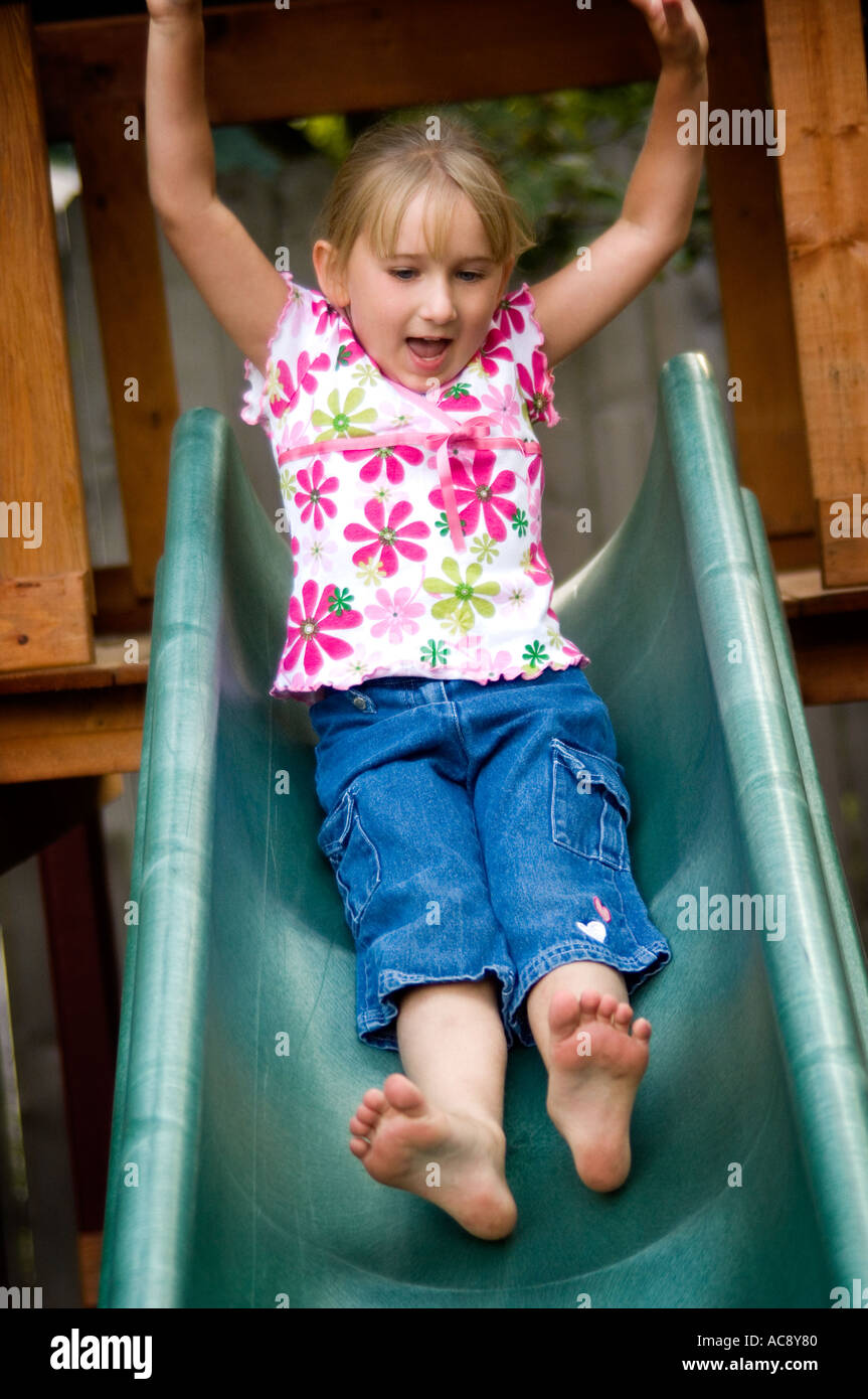 Girl going down slide Stock Photo - Alamy