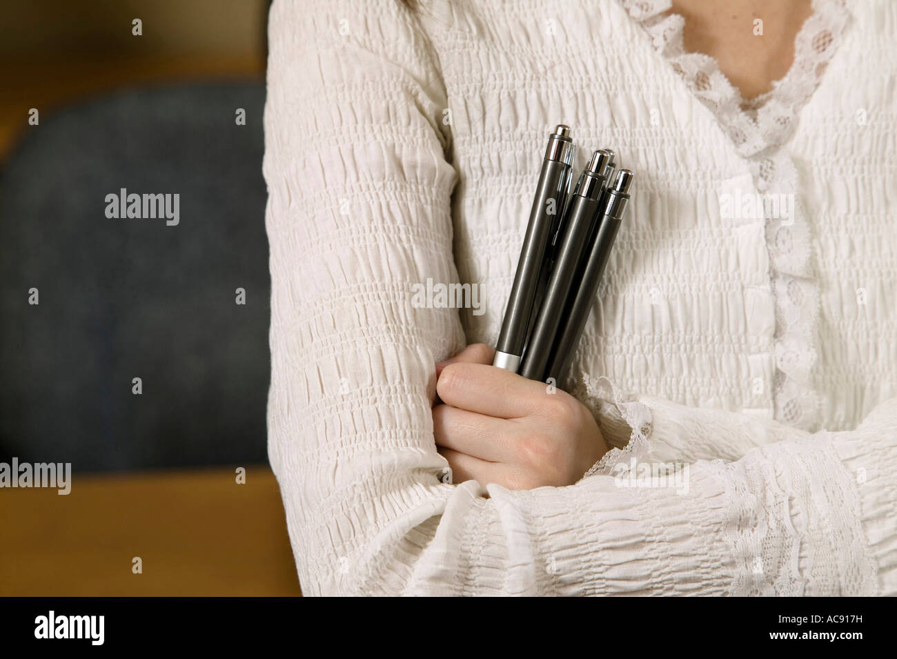 Close-up of a woman holding pens Stock Photo - Alamy