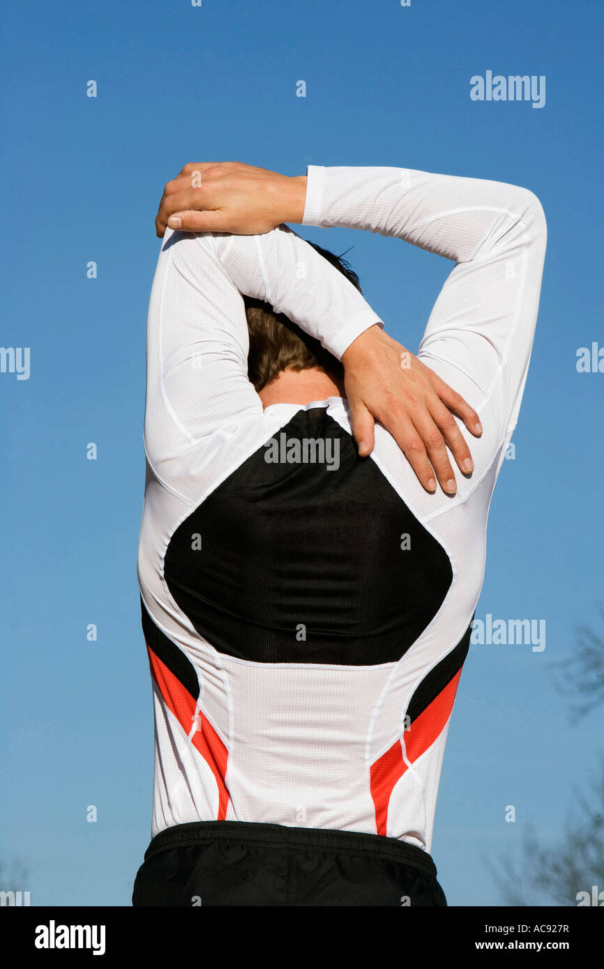 Rear view of a mid adult man stretching Stock Photo - Alamy