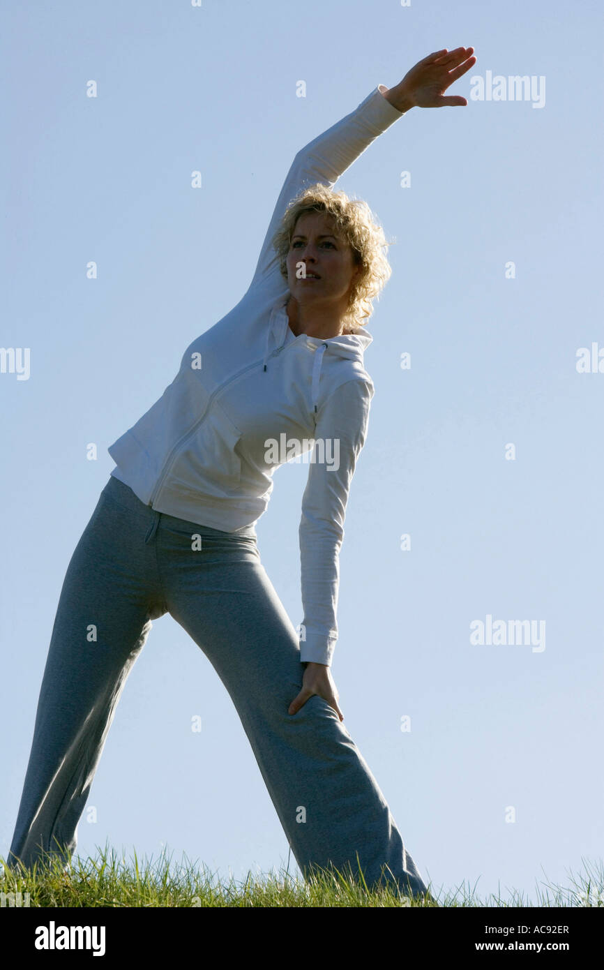 Mid adult woman standing and stretching Stock Photo - Alamy