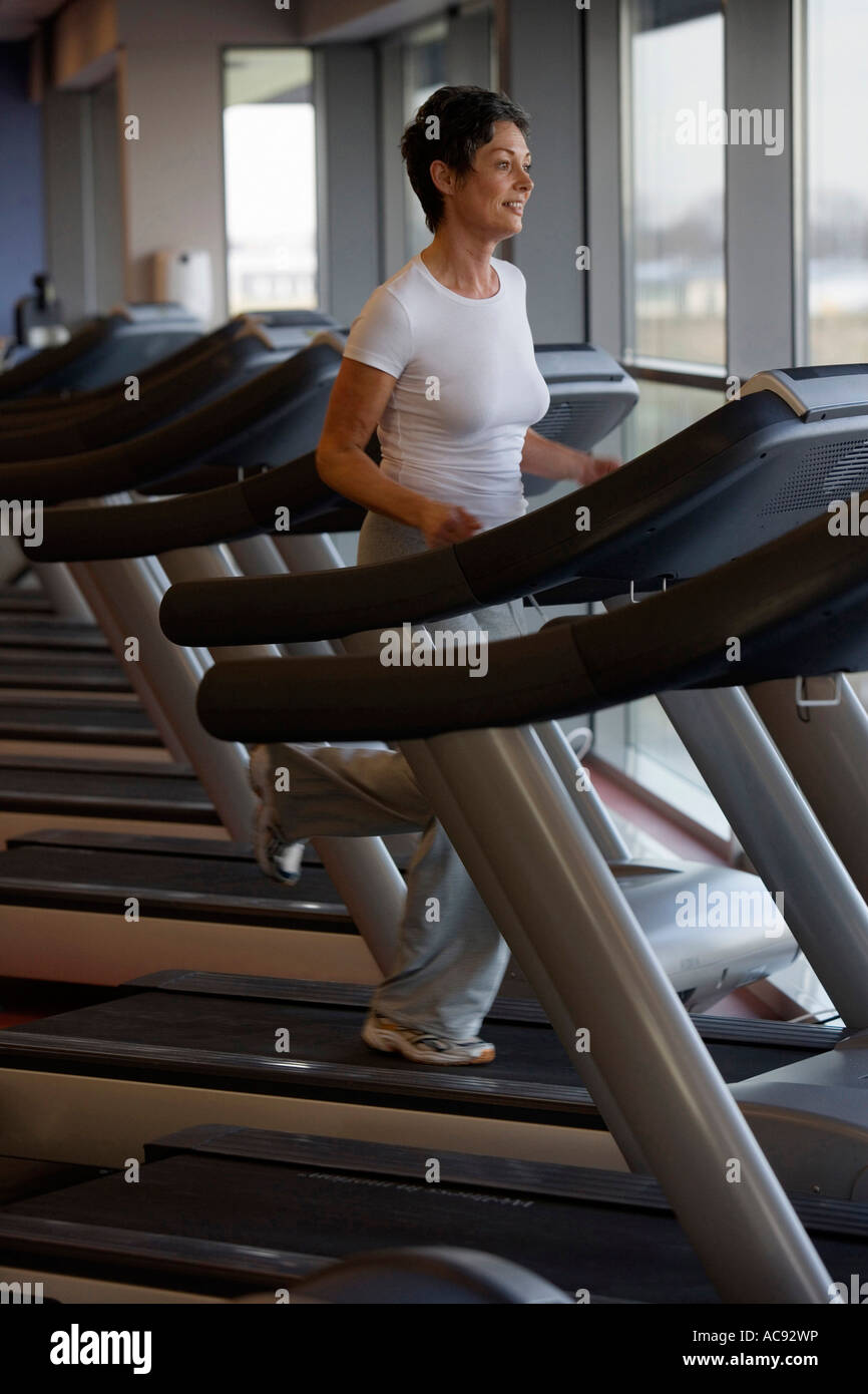Mature woman running on a treadmill Stock Photo - Alamy