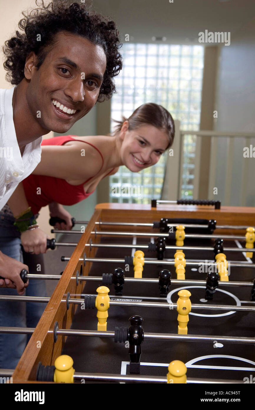 Teenage girl and a young man playing foosball Stock Photo - Alamy