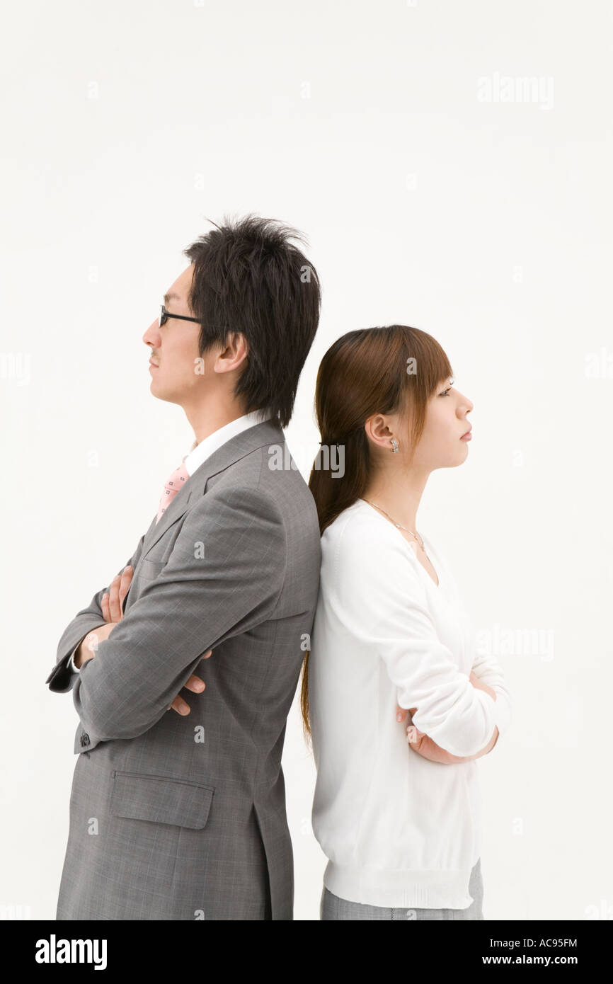 Two business people standing back to back Stock Photo - Alamy