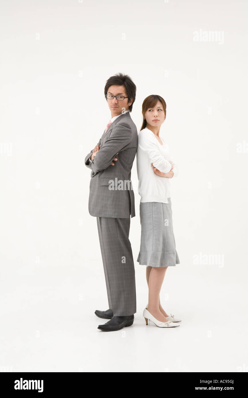 Two business people standing back to back Stock Photo - Alamy