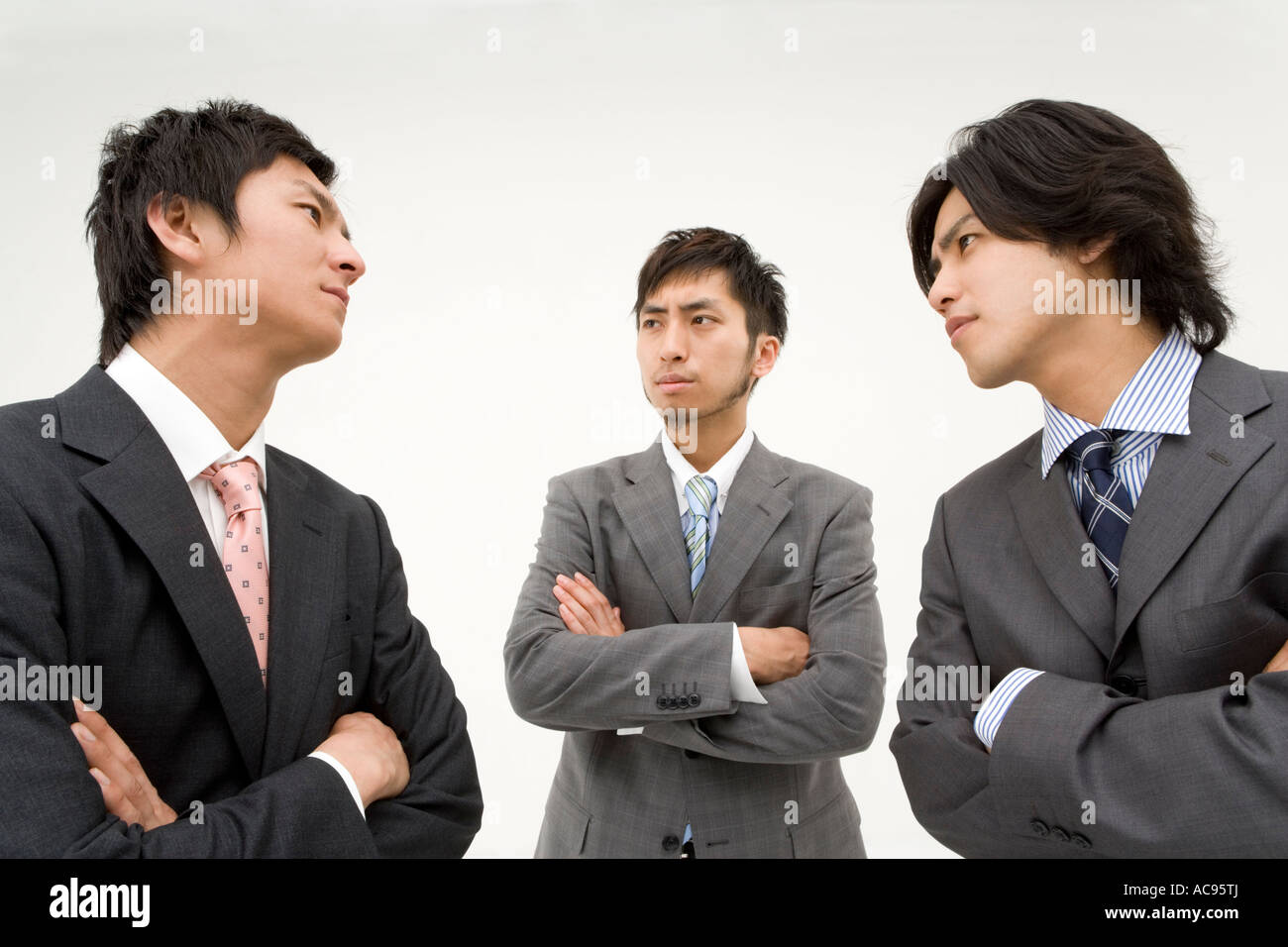 Three businessmen glaring at each other Stock Photo - Alamy