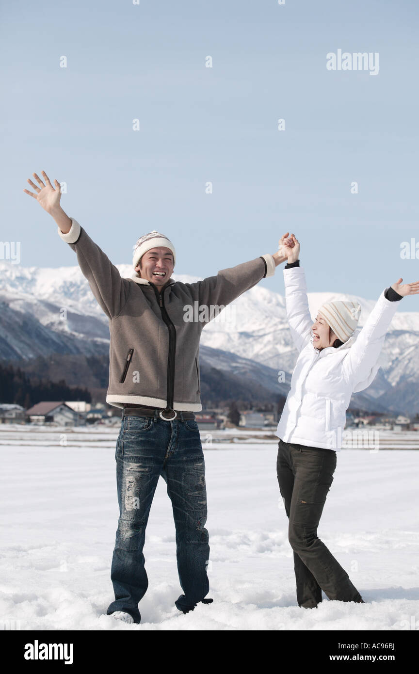 Young couple standing in snow Stock Photo - Alamy