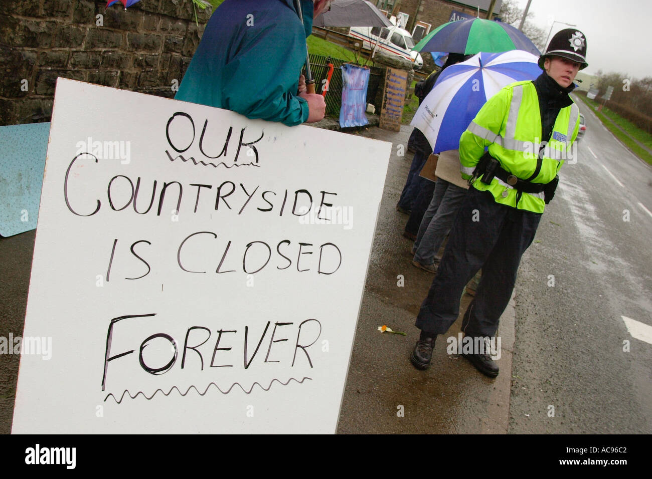 Protestor with placard under police supervision in Trecastle Powys ...
