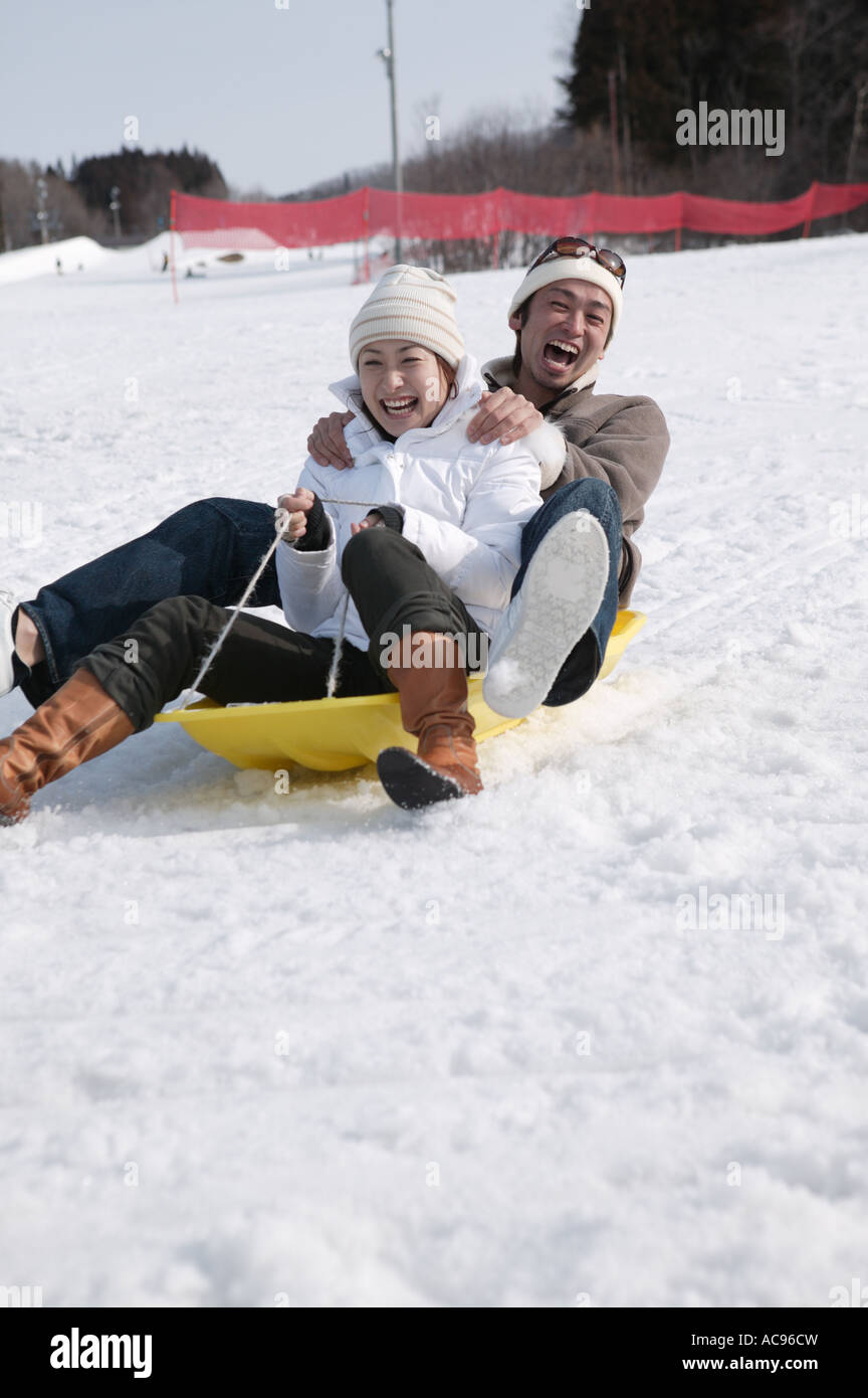 Young couple sledding Stock Photo - Alamy