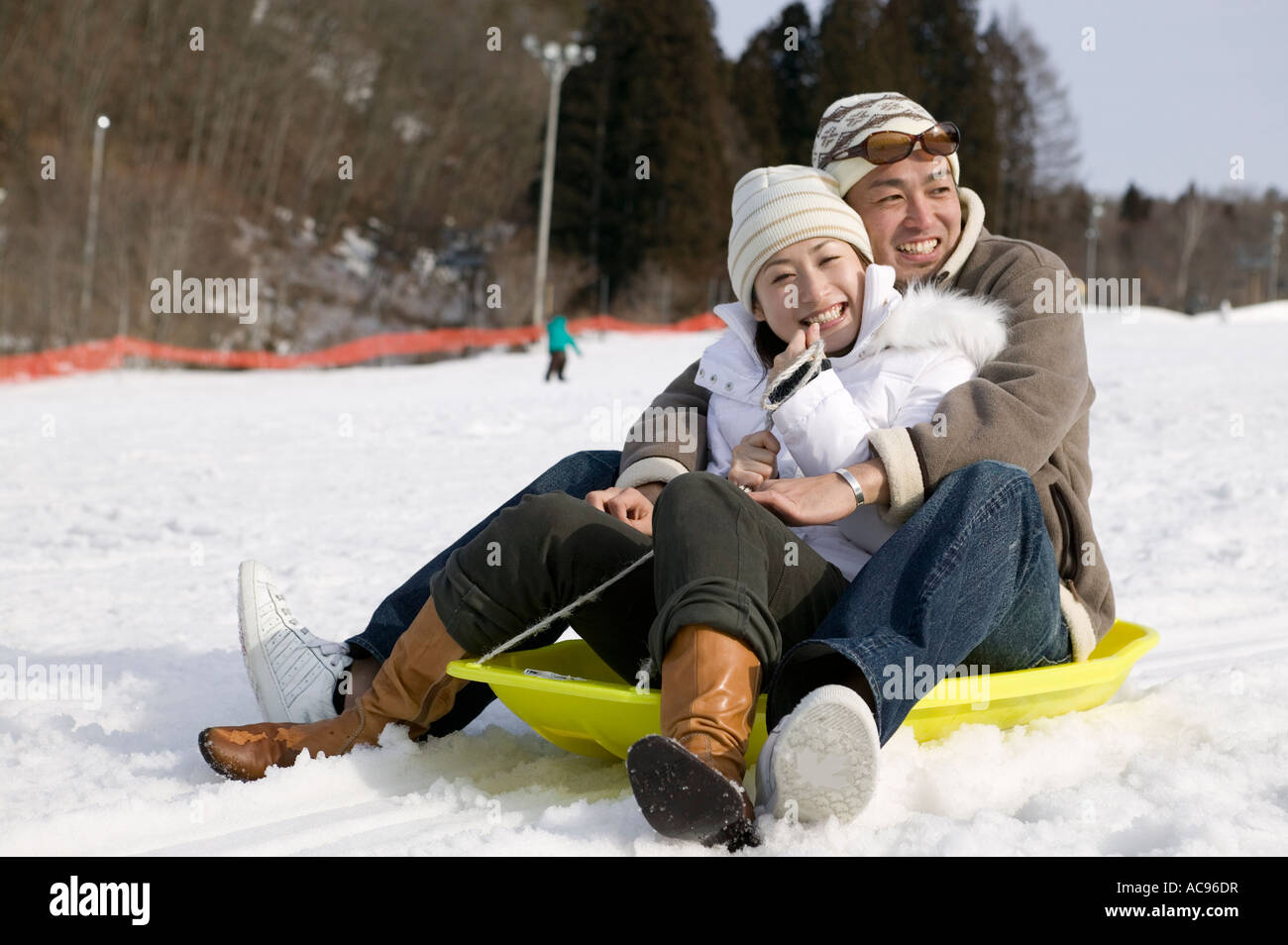 Young couple sledding Stock Photo - Alamy