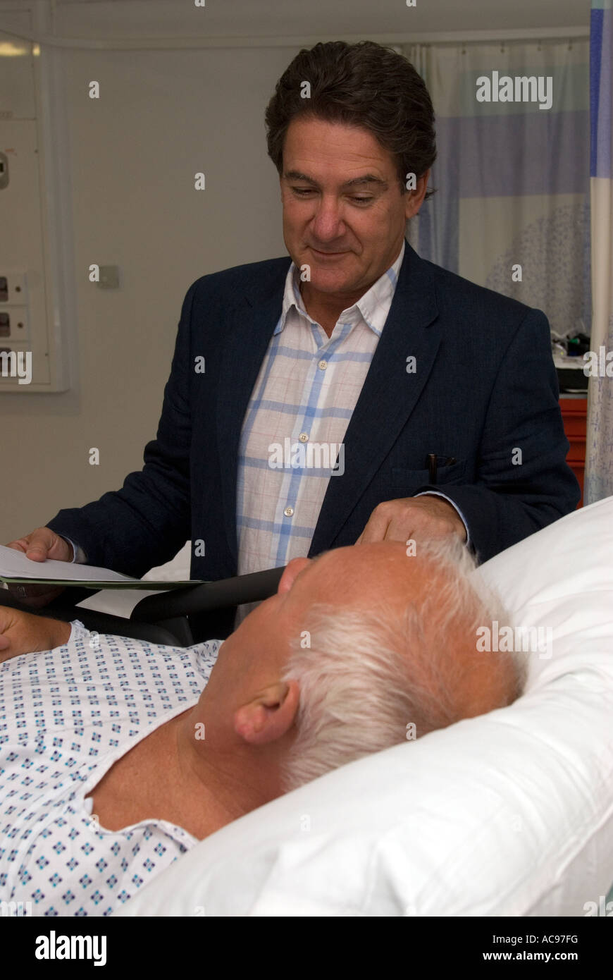 Patient being overseen by GP in recovery room following an operation at ...