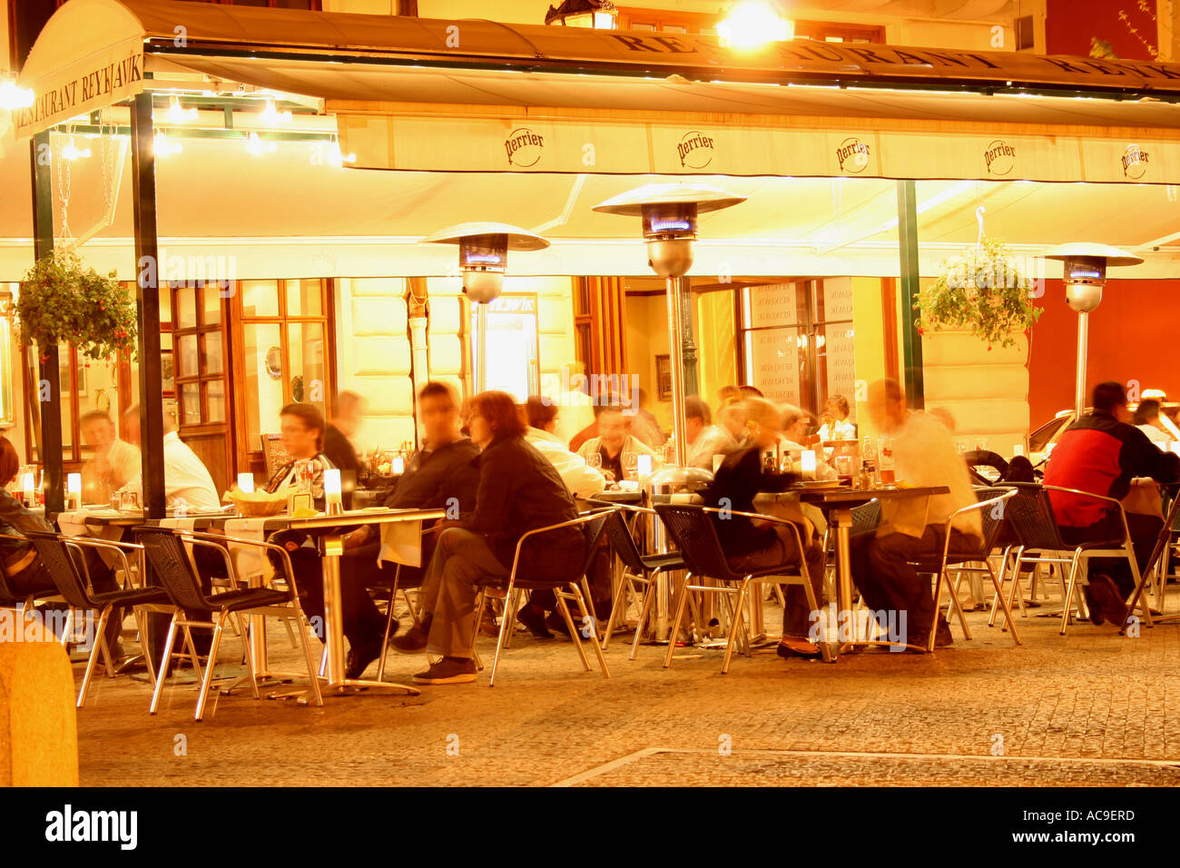 Outdoor restaurant scene in Prague at night with people dining under ...