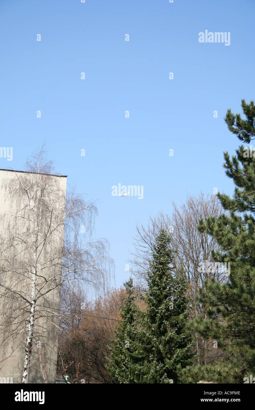 Urban landscape with trees and a building under a clear blue sky ...