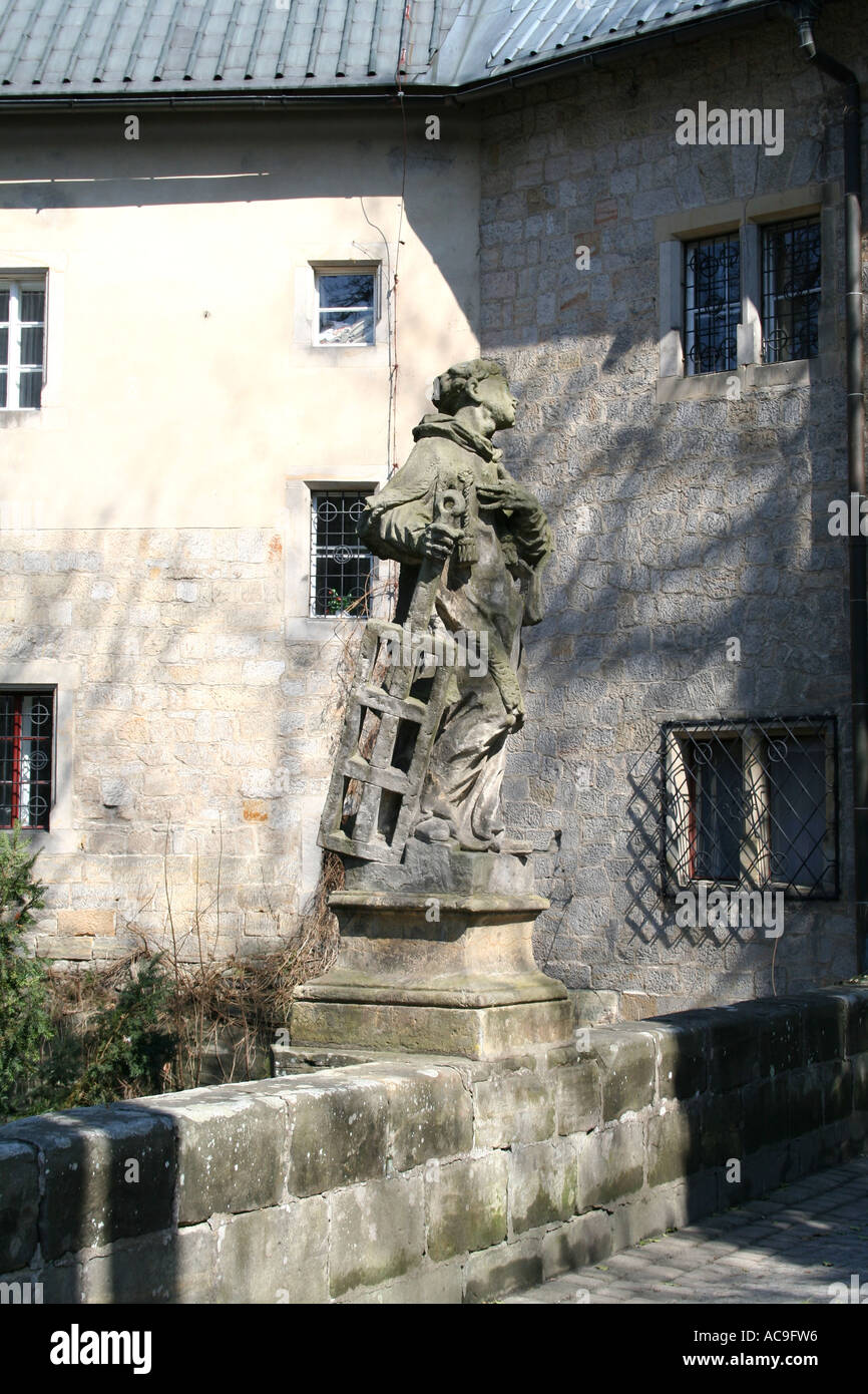 Historic statue of a saint against an old building under a clear blue ...