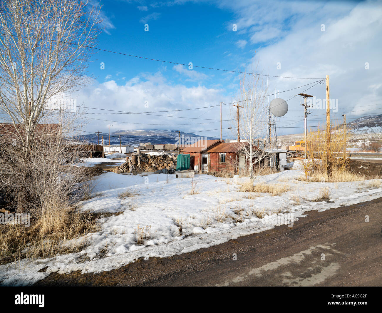 House with firewood with dirt road in foreground Stock Photo - Alamy