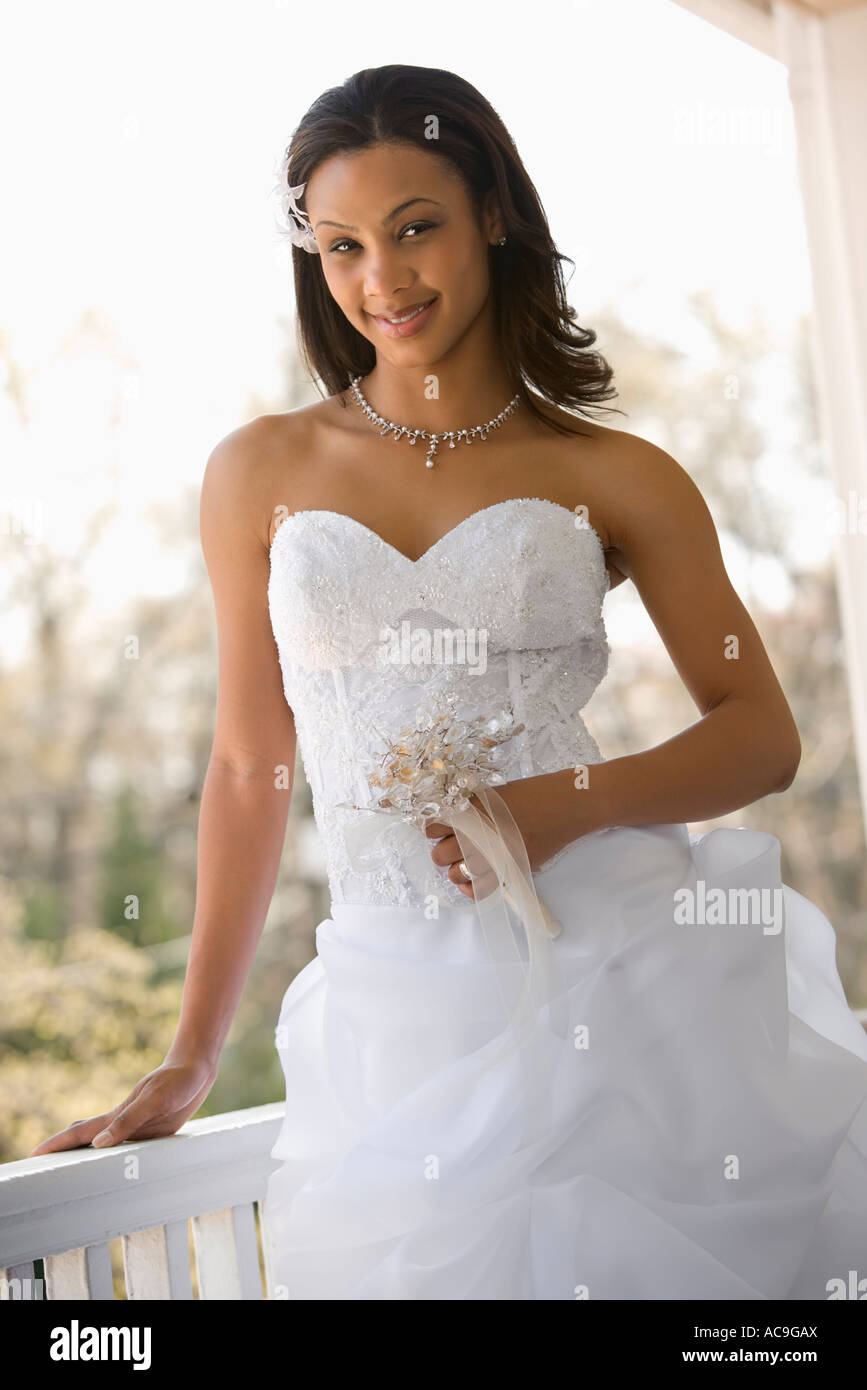 Portrait of African American bride leaning against railing Stock Photo ...