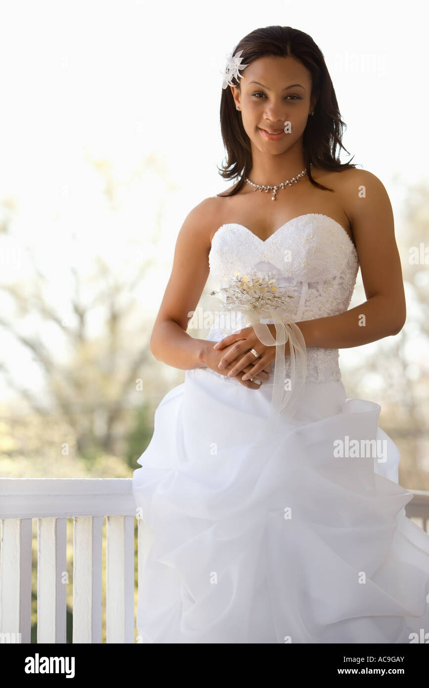 Portrait of African American bride leaning against railing Stock Photo ...