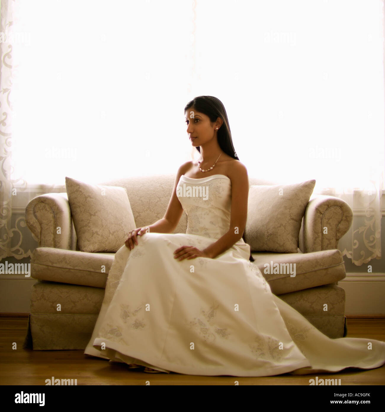 Portrait of an Indian bride sitting on a love seat Stock Photo - Alamy