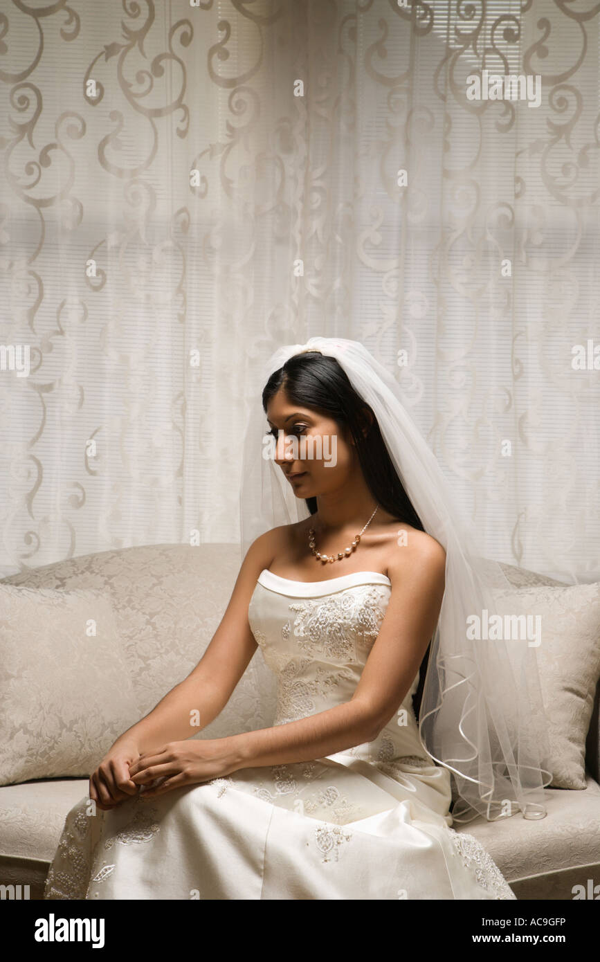 Portrait of an Indian bride sitting on a love seat Stock Photo - Alamy