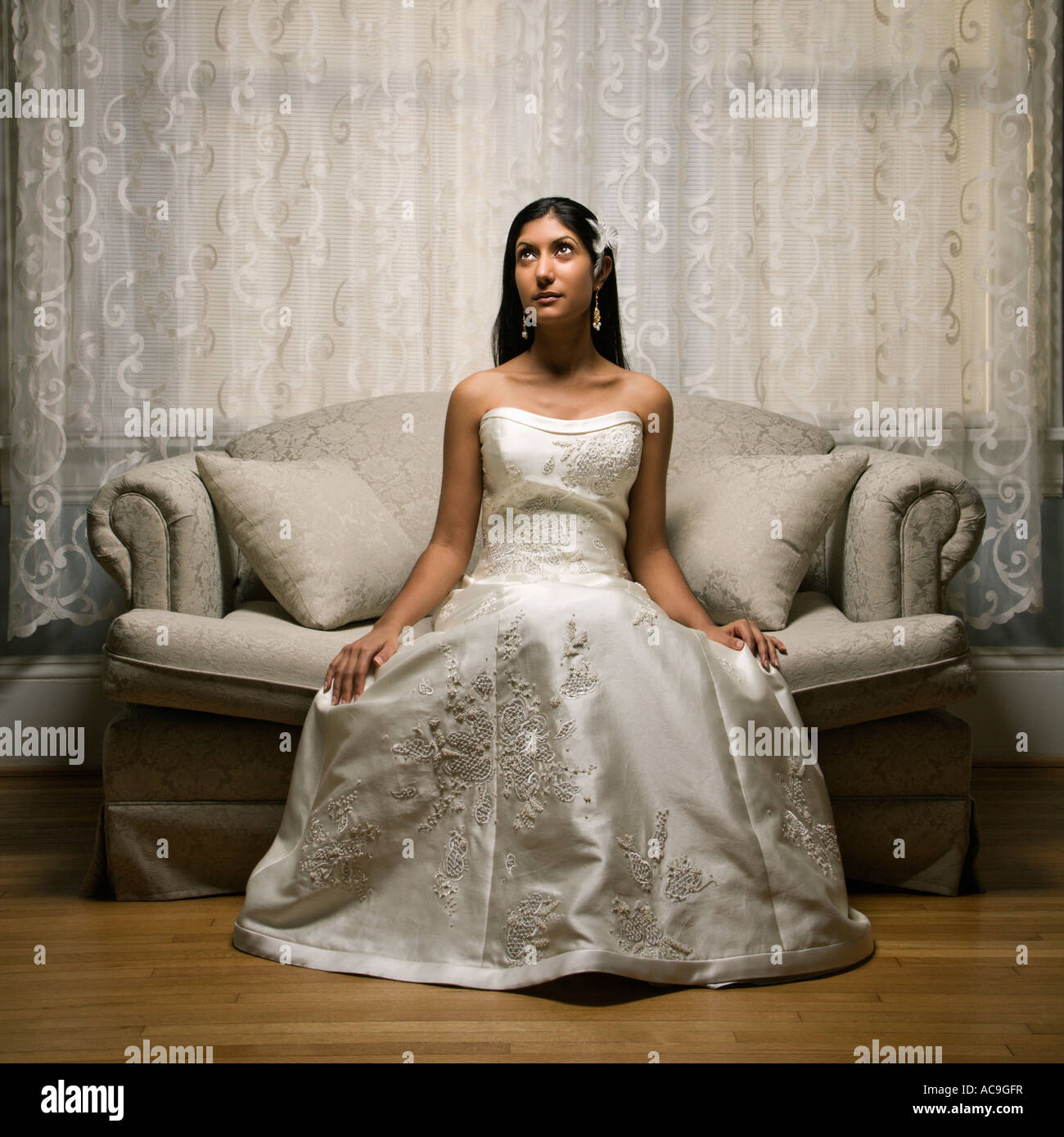 Portrait of an Indian bride sitting on a love seat Stock Photo - Alamy