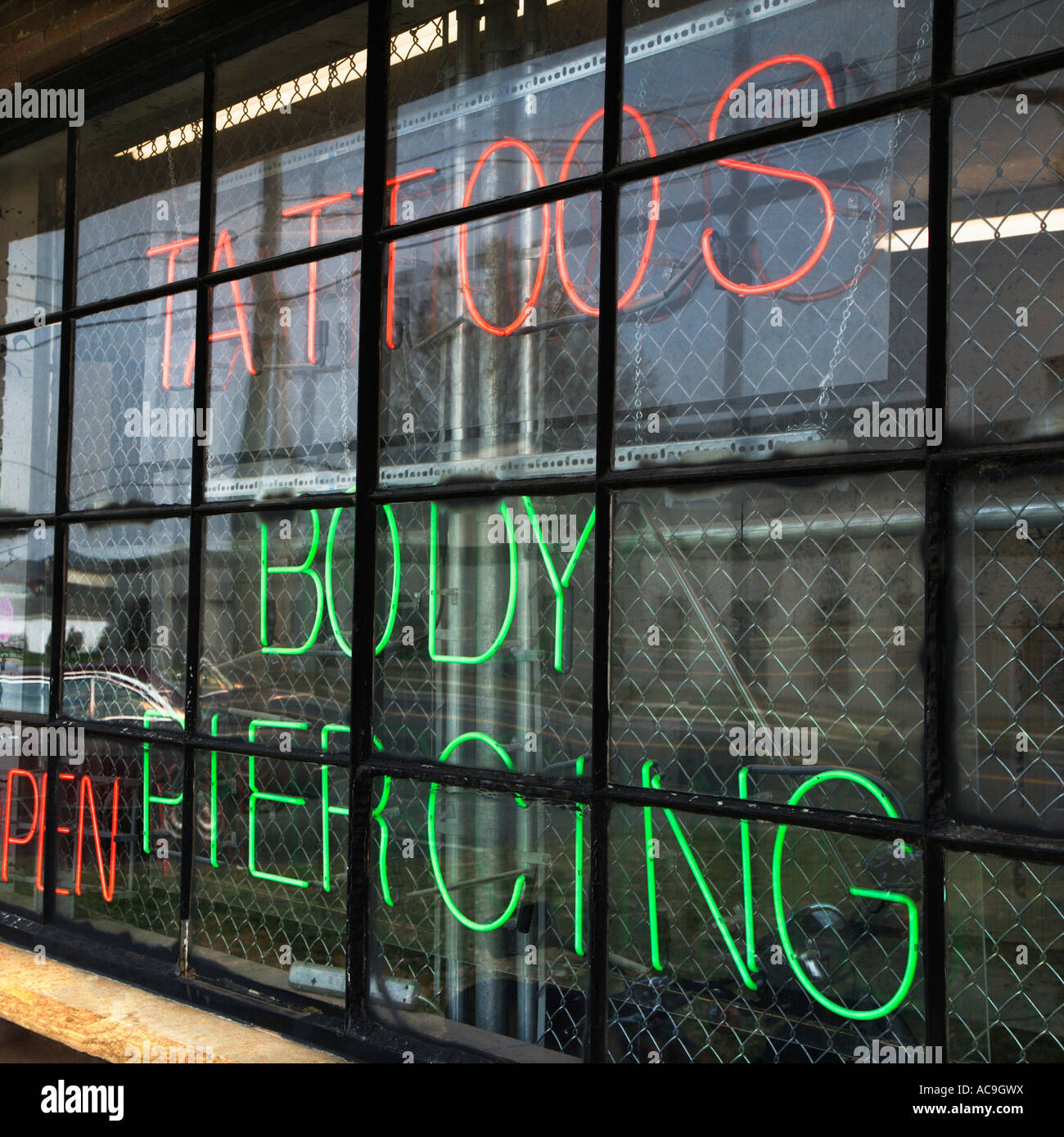 Neon sign in window for tattoos and body piercing Stock Photo - Alamy