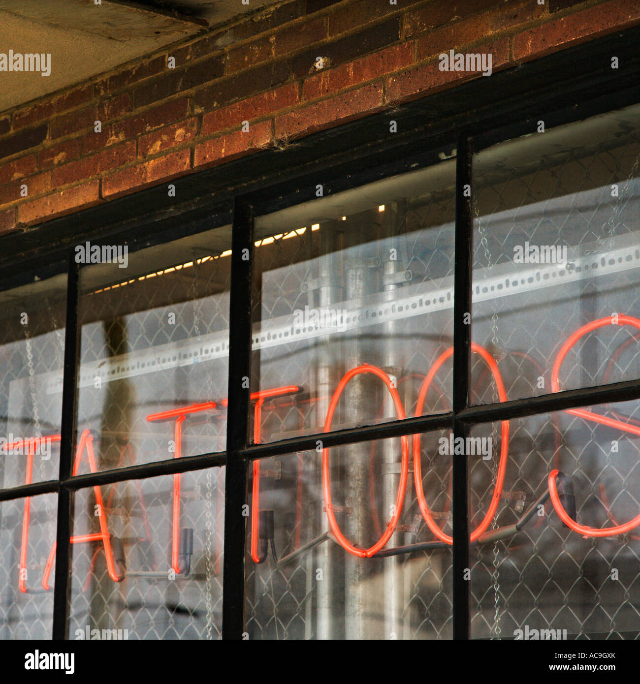 Neon sign in window for tattoos and body piercing Stock Photo - Alamy