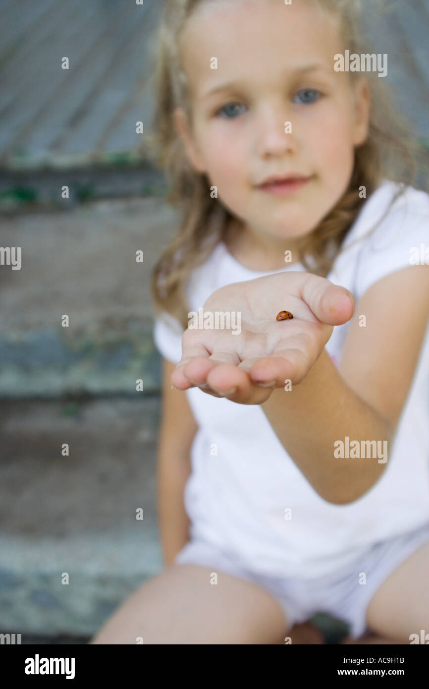 Girl holding ladybug Stock Photo - Alamy