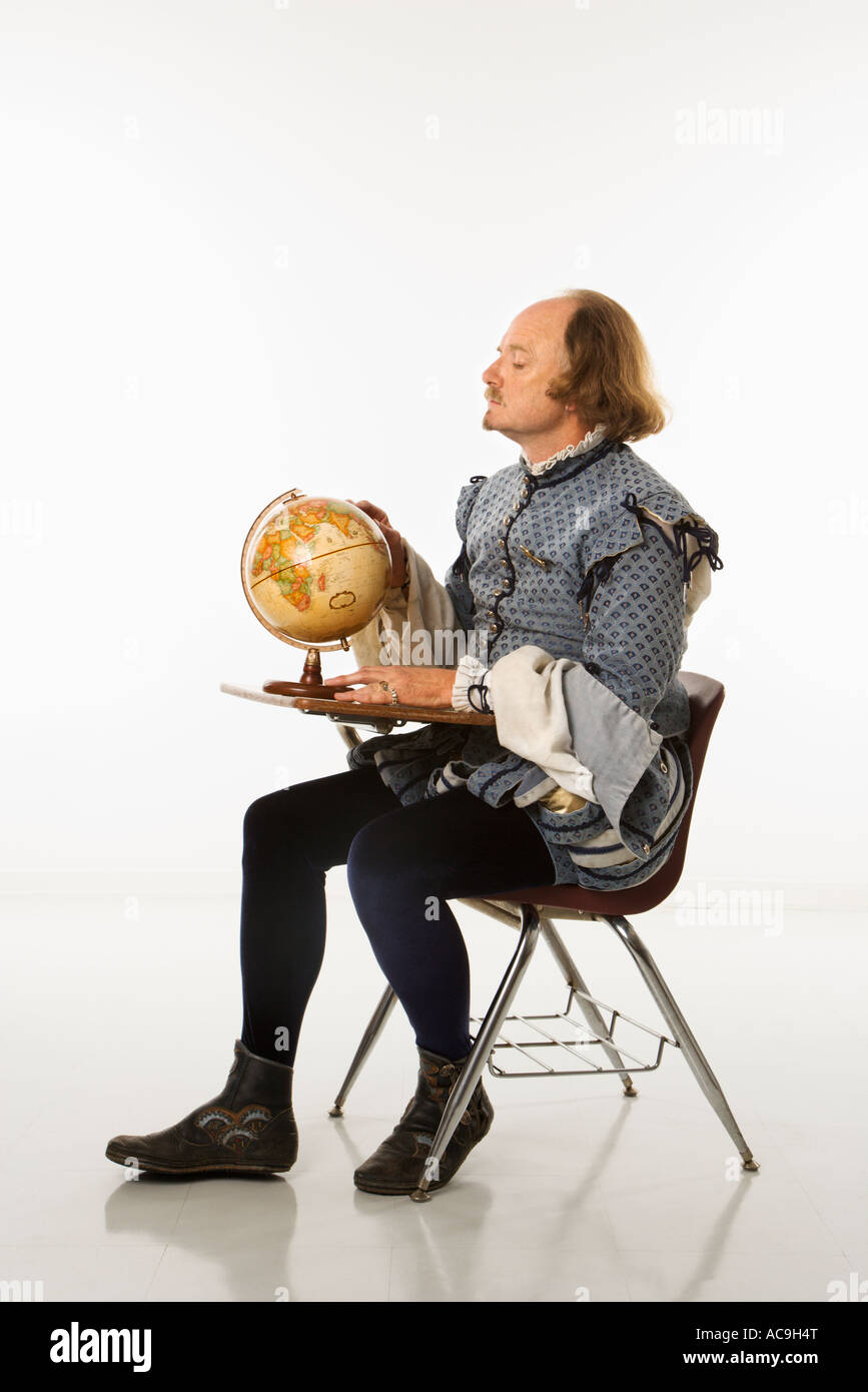 William Shakespeare in period clothing sitting in school desk looking ...