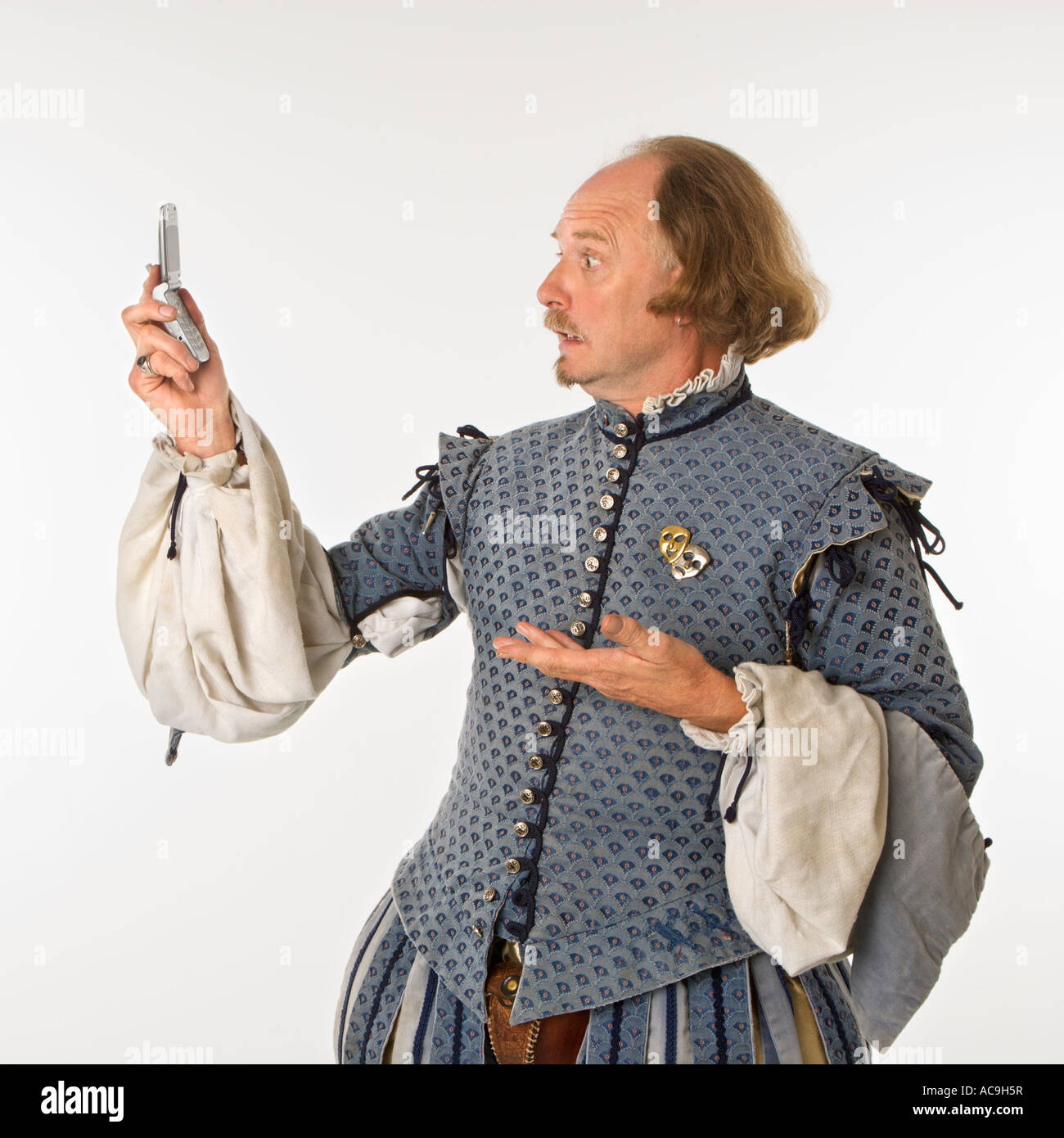 William Shakespeare in period clothing looking at cell phone with ...