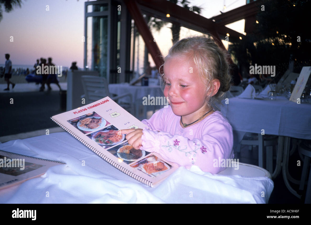 Lucy reading picture menu at a Benidorm restaurant Spain Stock Photo ...