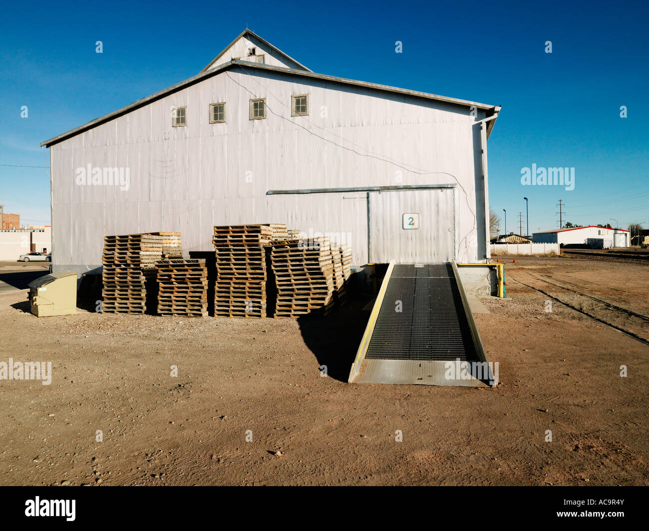Storage warehouse with ramp and palettes in rural setting Stock Photo ...