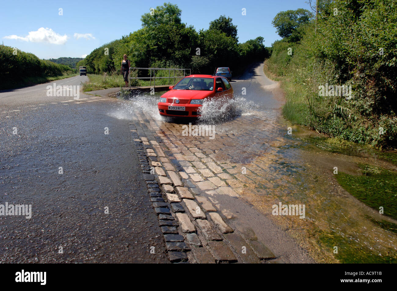A car at a ford river crossing in the Piddlevalley in Dorset England UK ...