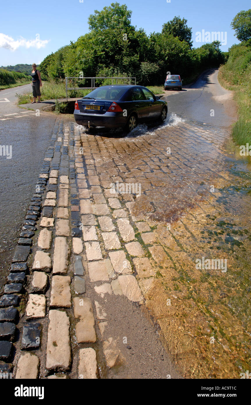 A car at a ford river crossing in the Piddlevalley in Dorset England UK ...