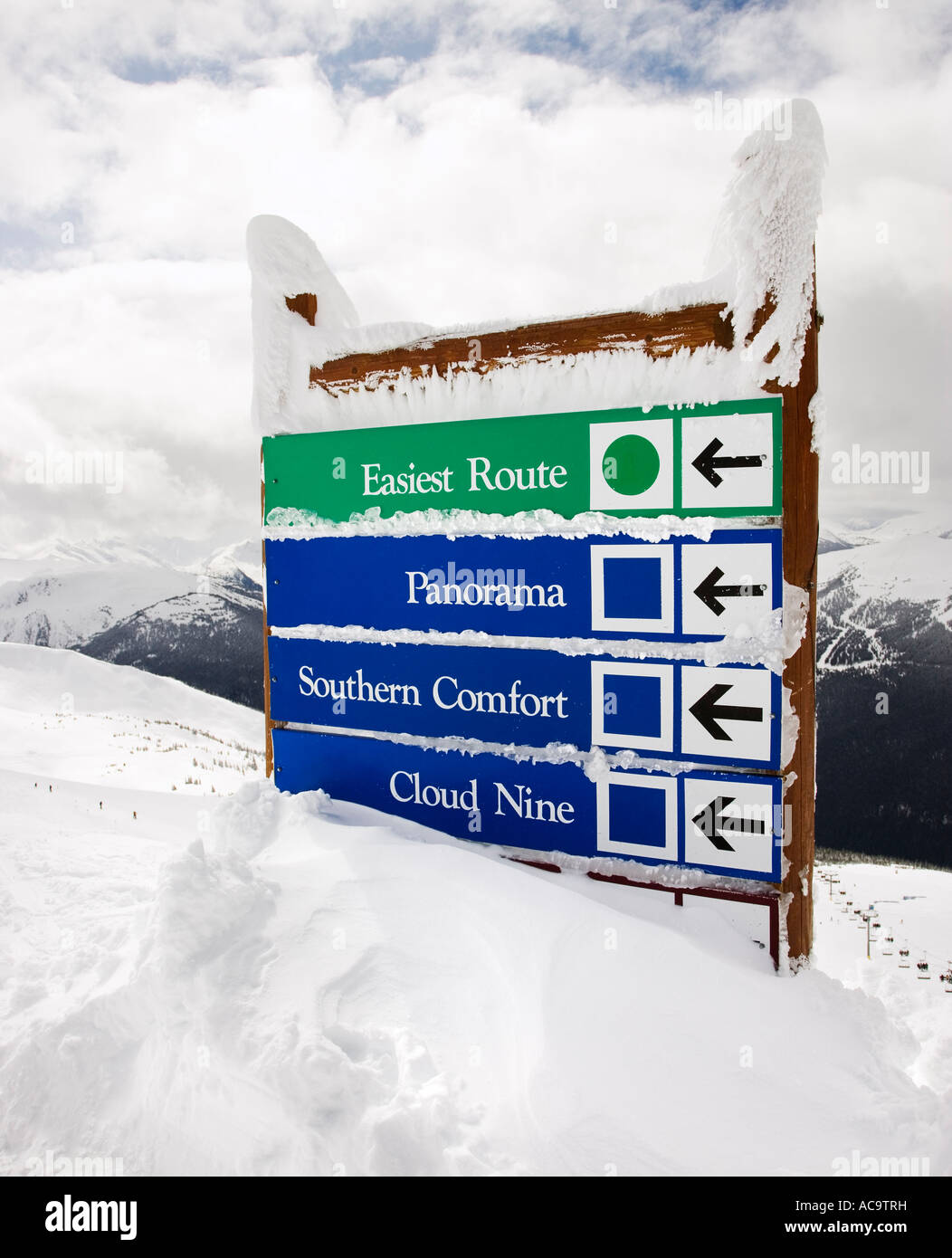 Snow covered sign with arrows to slopes Stock Photo - Alamy
