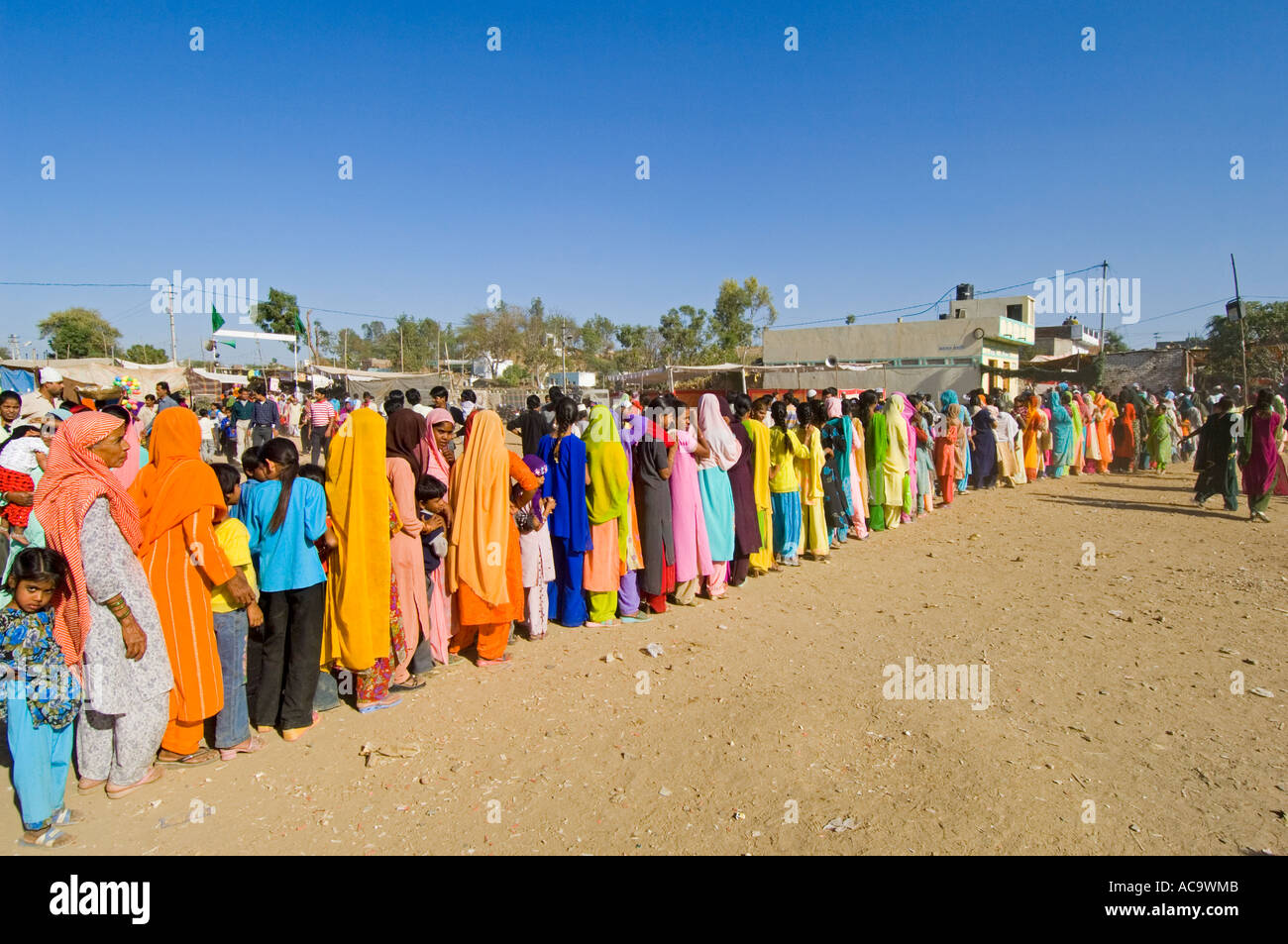 A long queue of women and girls dressed in their finest clothes waiting ...