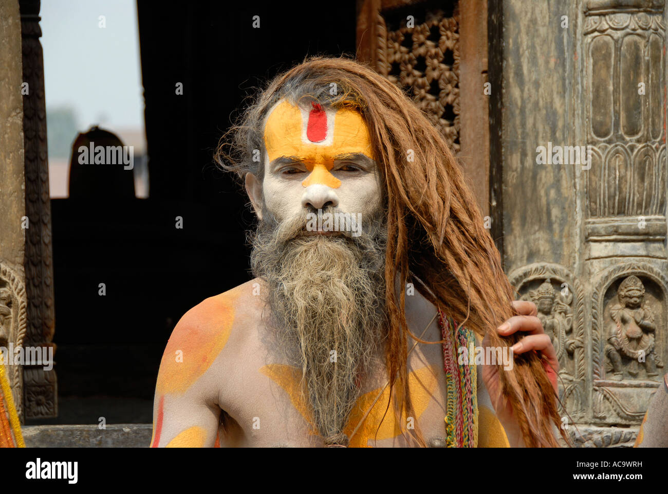 Holy man sadhu colourfully painted with long beard and rasta hairs ...