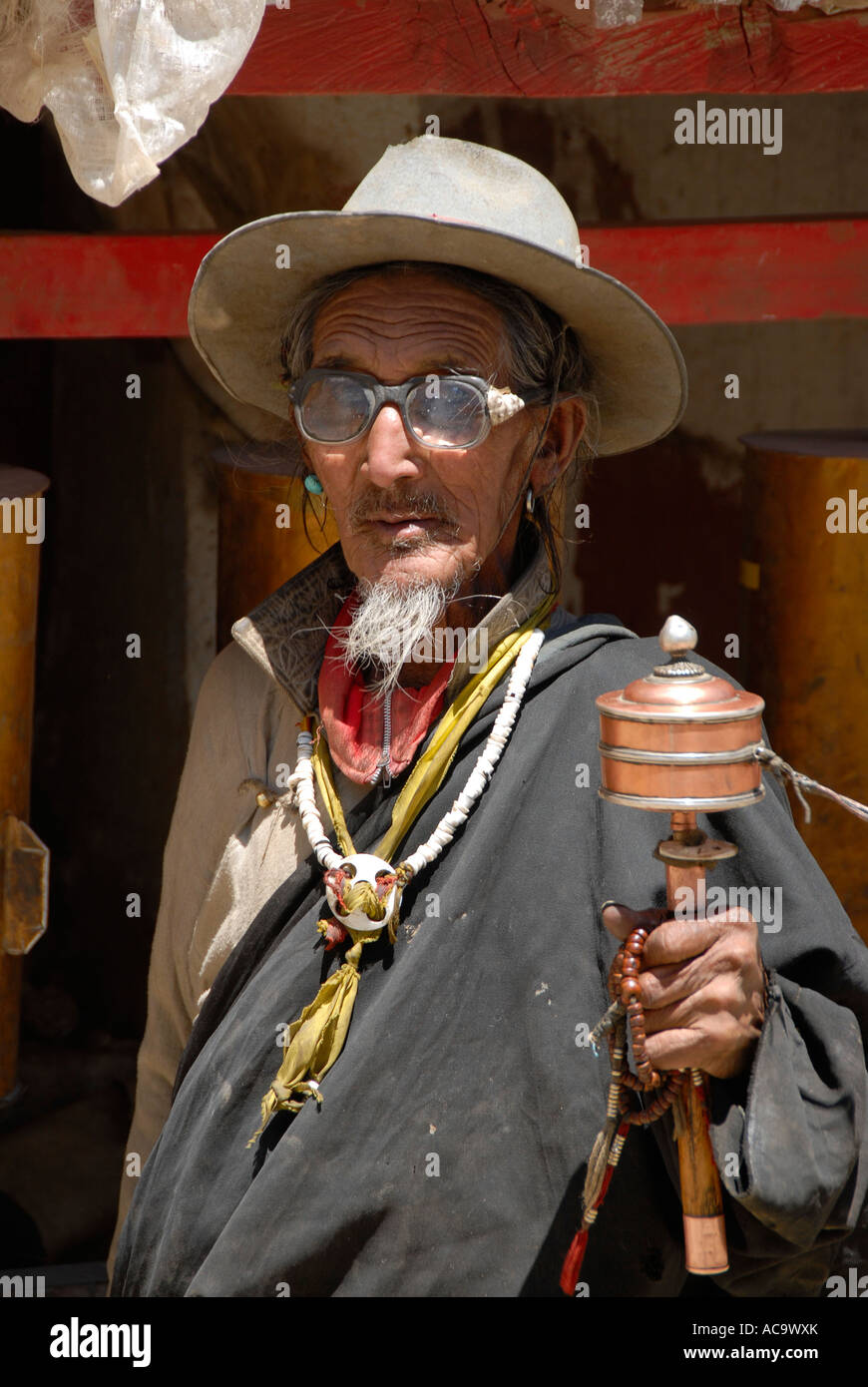 Tibetan Buddhism pilgrim with beard turns prayer wheel Shegar town ...